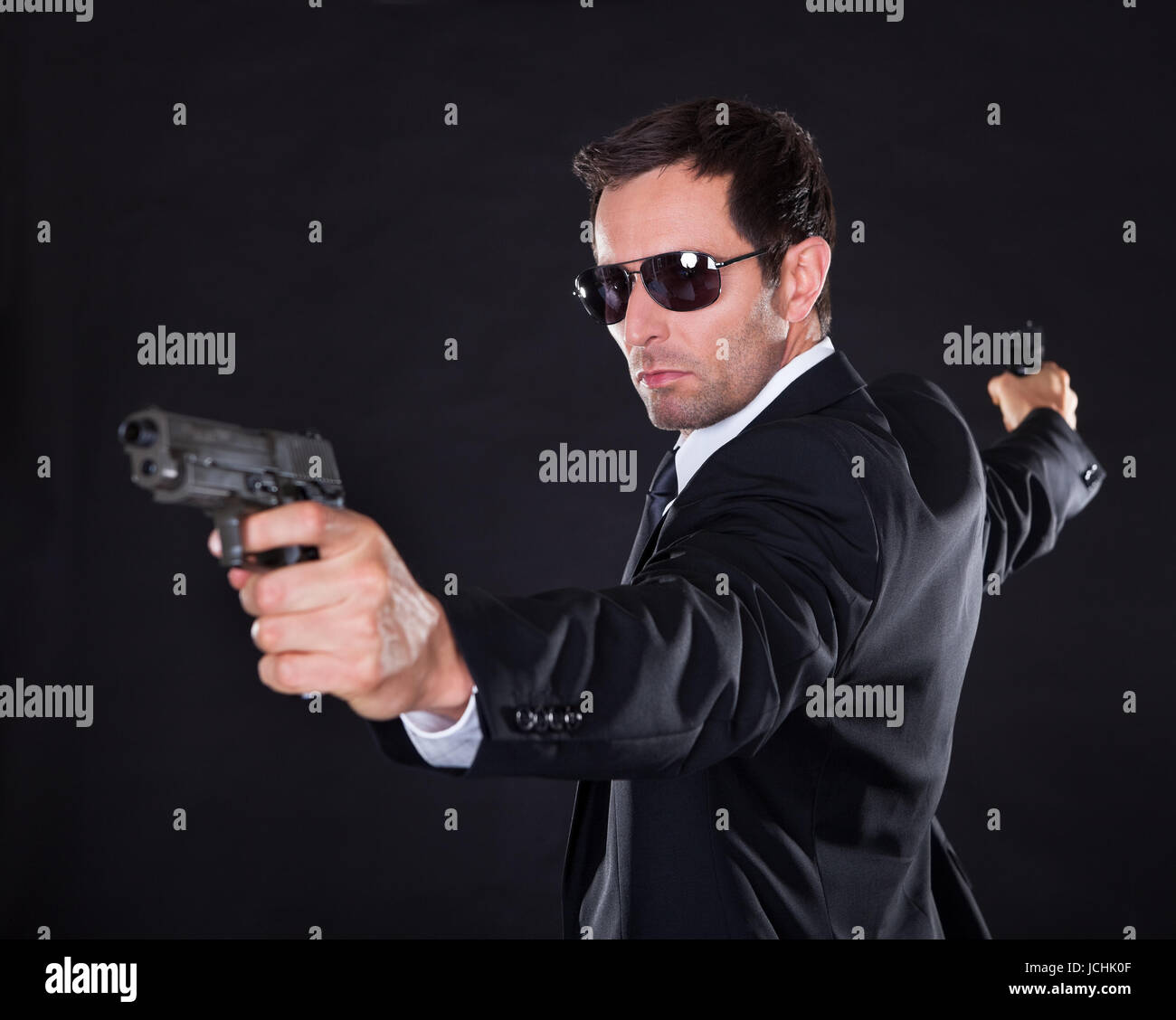 Portrait Of Young Man With Gun On Black Background Stock Photo - Alamy