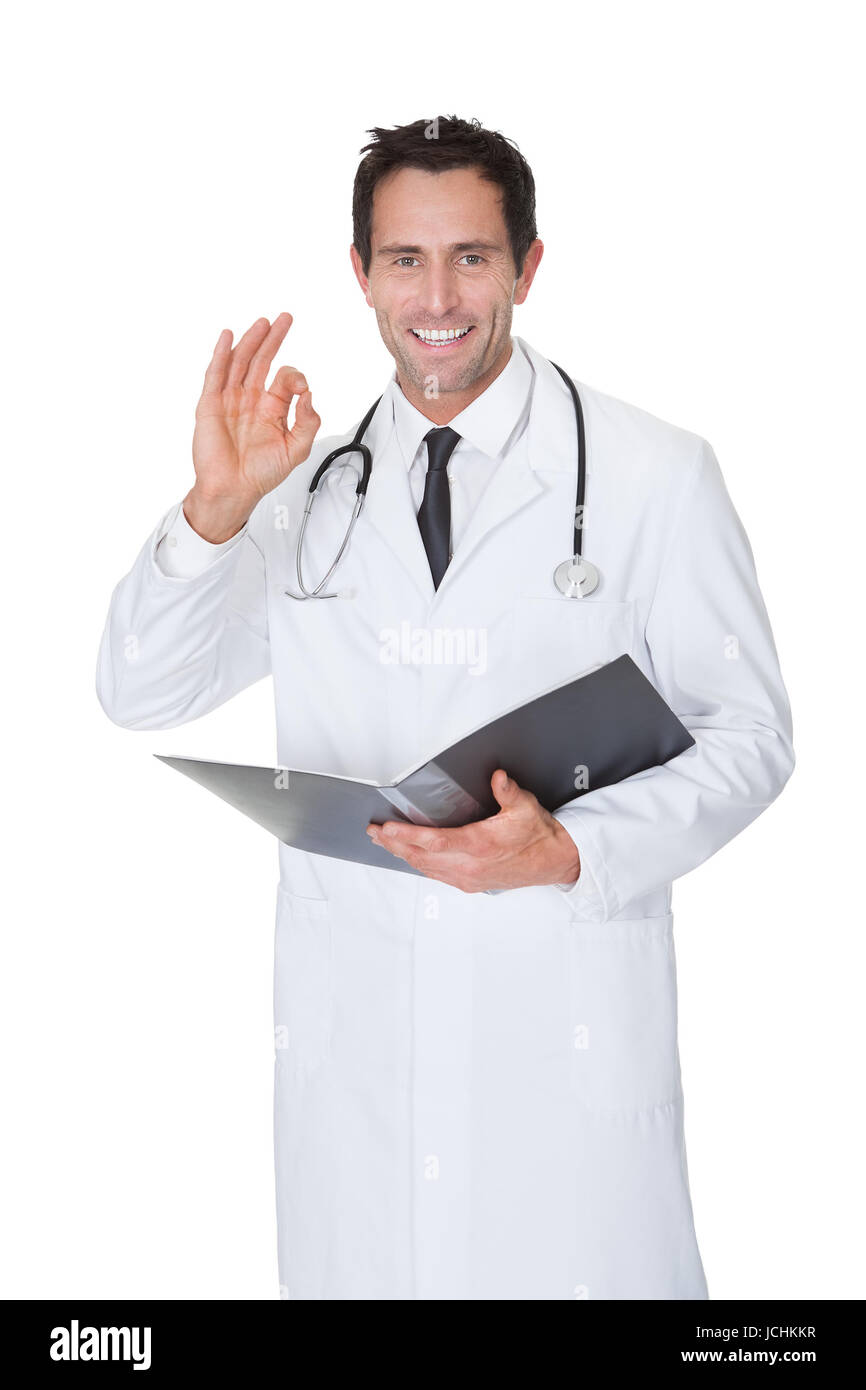 Portrait of friendly doctor making Okay gesture. Isolated on white ...