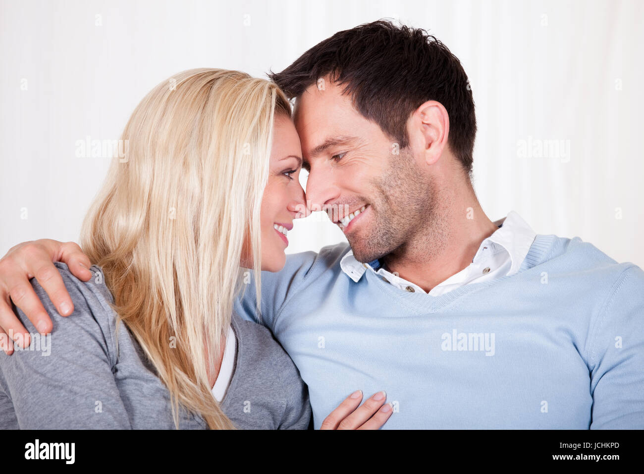Romantic young couple expressing their love by rubbing noses as they ...