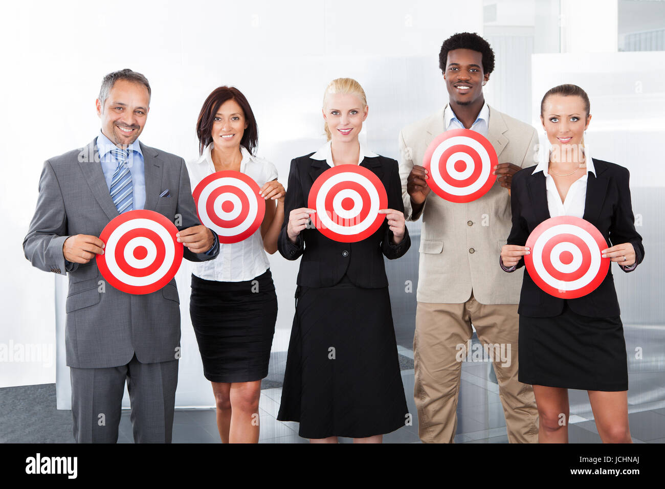 Group Of Businesspeople Holding Dartboard In Front Of Face Stock Photo ...