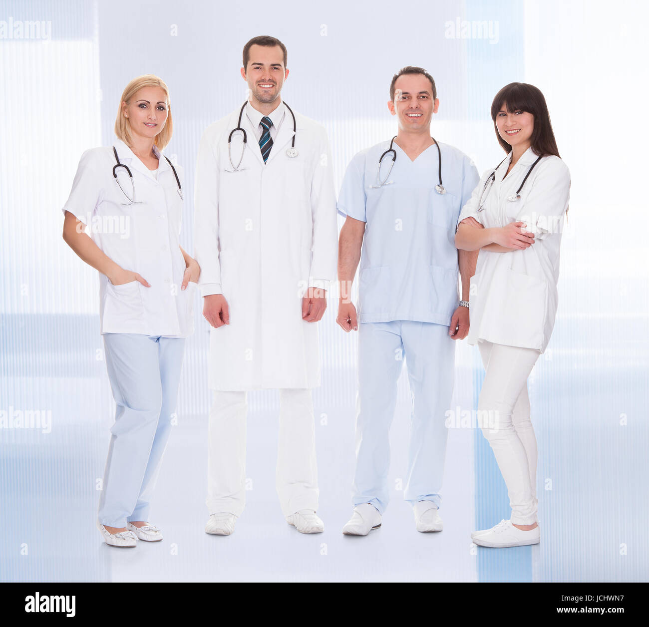 Happy Group Of Doctors Standing Over Blue Background Stock Photo - Alamy