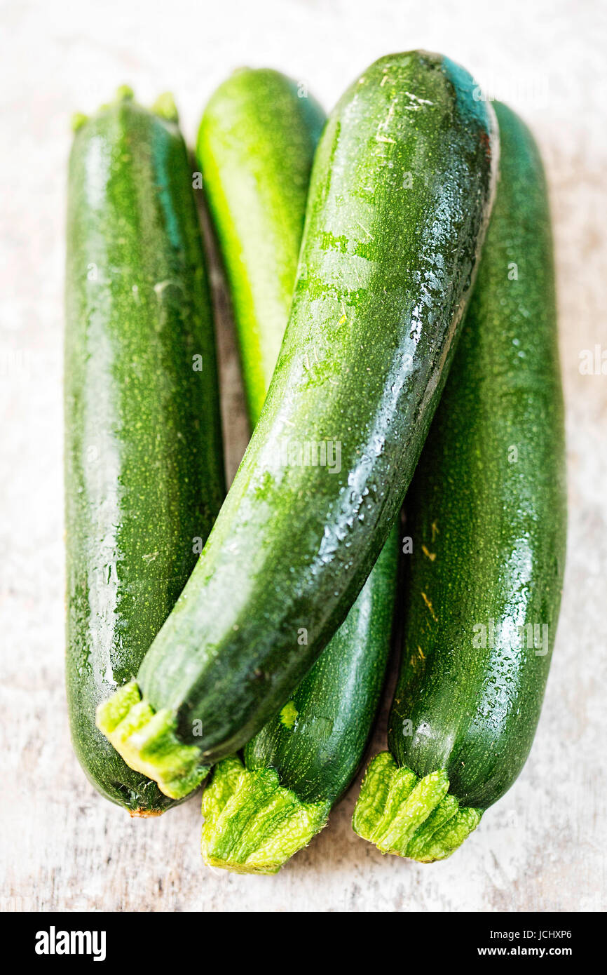 Four courgettes on white background Stock Photo - Alamy