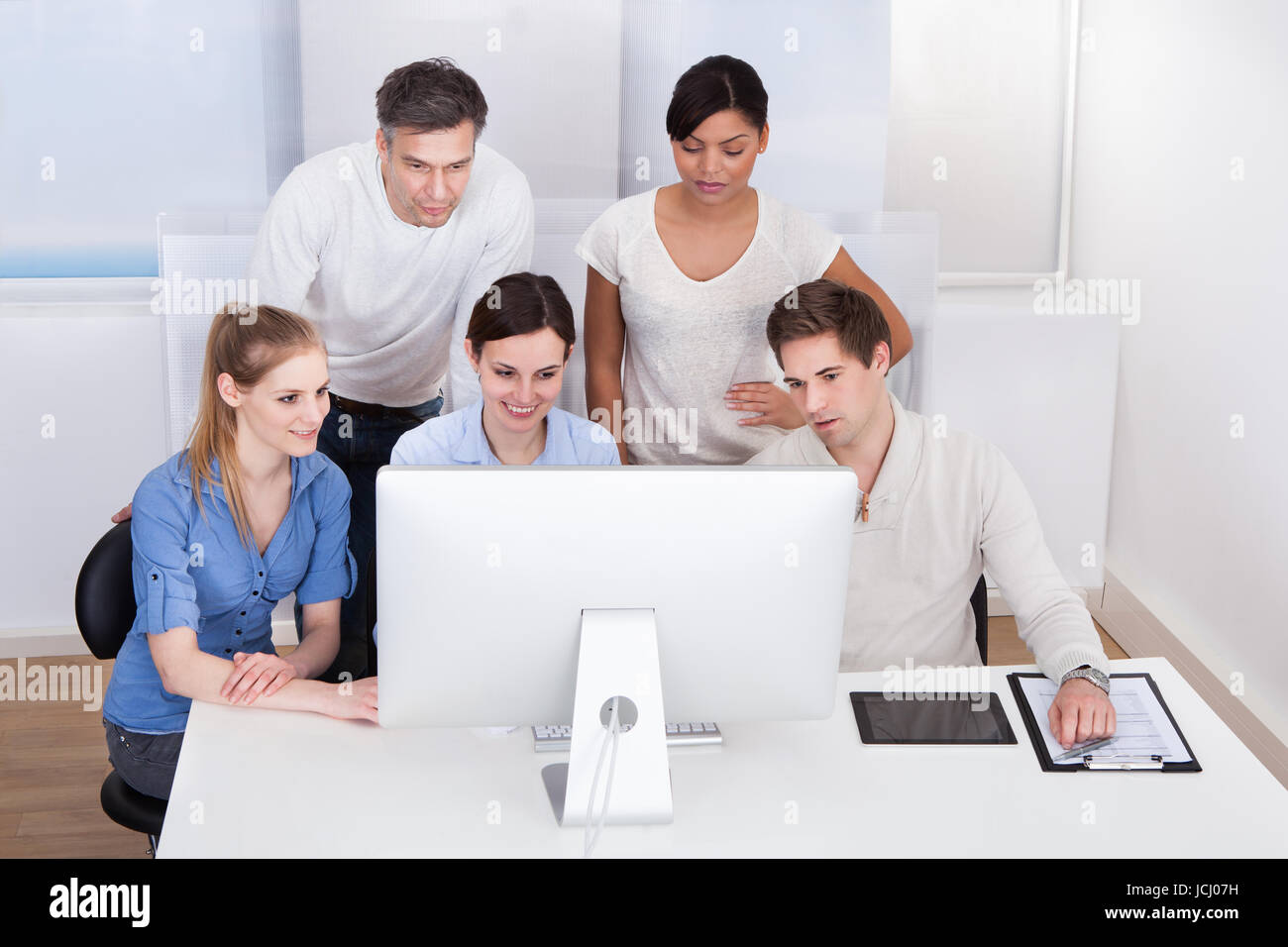Group Of Happy Businesspeople Working On Computer At Office Stock Photo ...