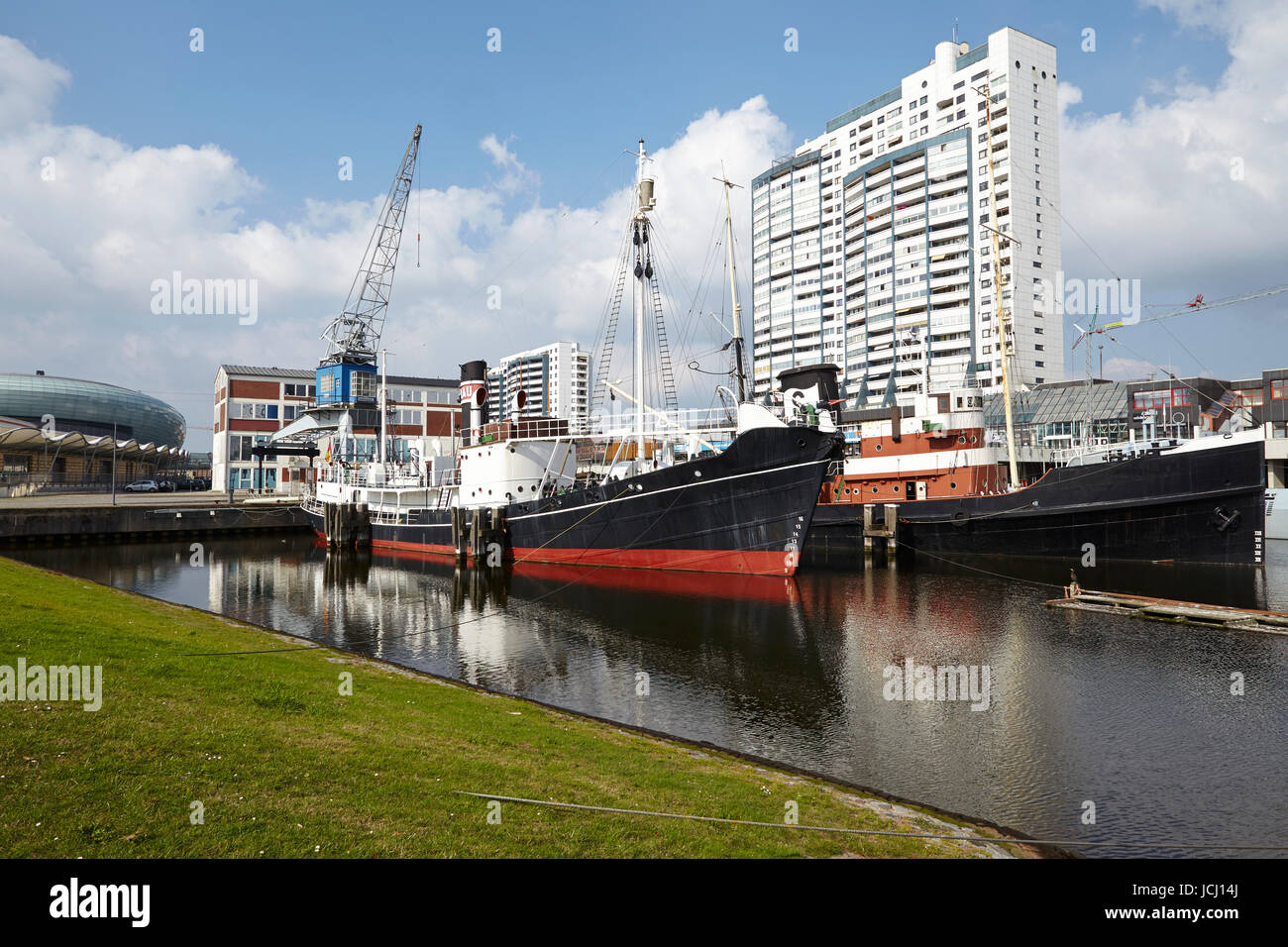 The harbour basin with historical ships and residental towers at the ...