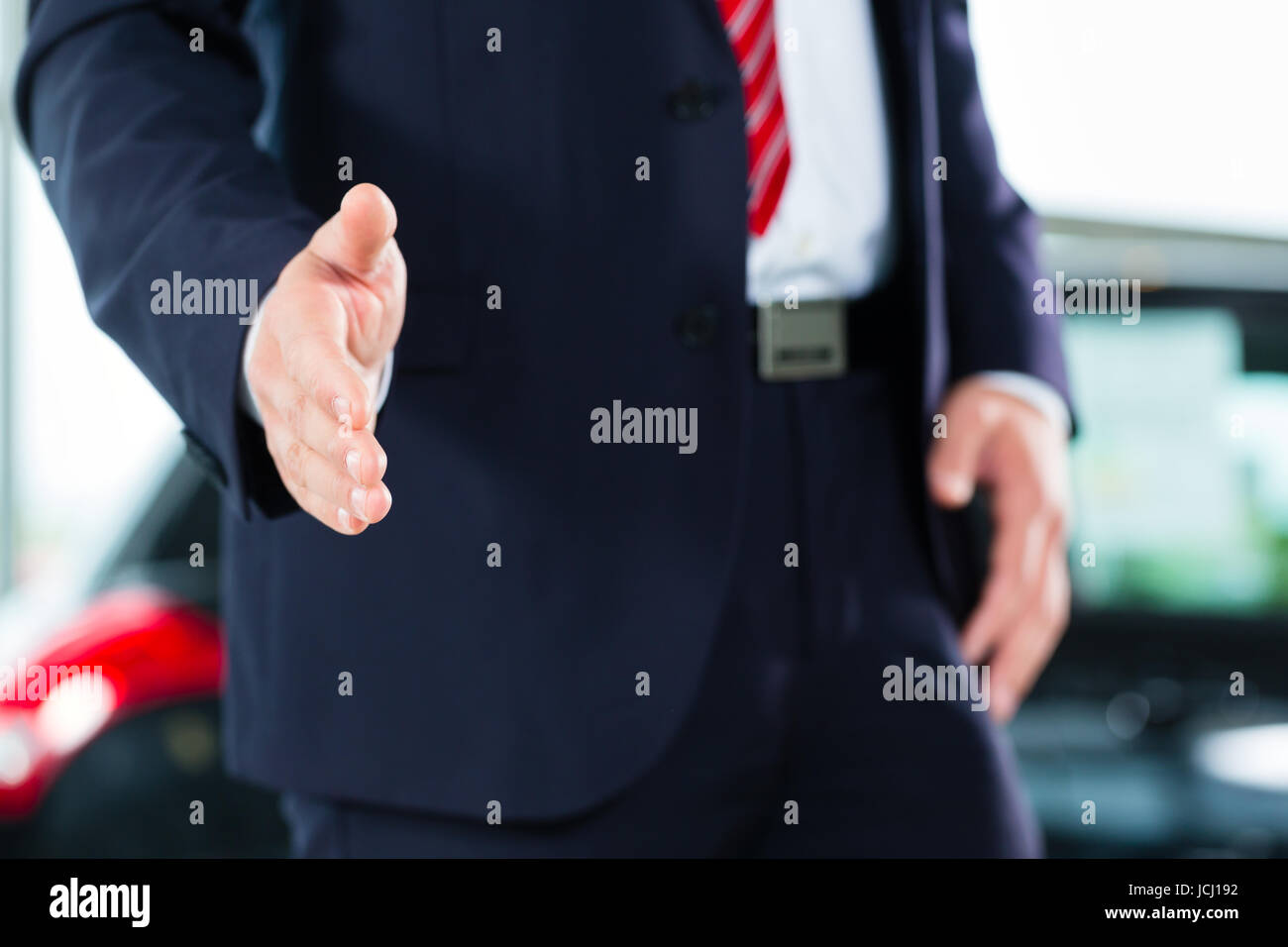 Seller or car salesman in car dealership presenting his new and used ...