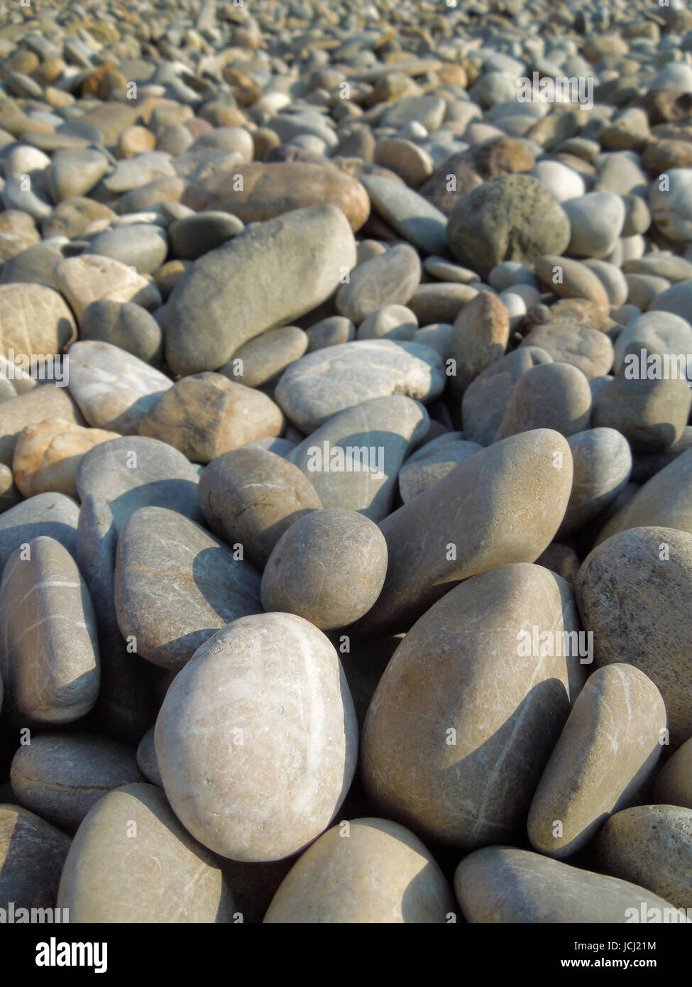 sunny illuminated full frame pebbles background Stock Photo - Alamy