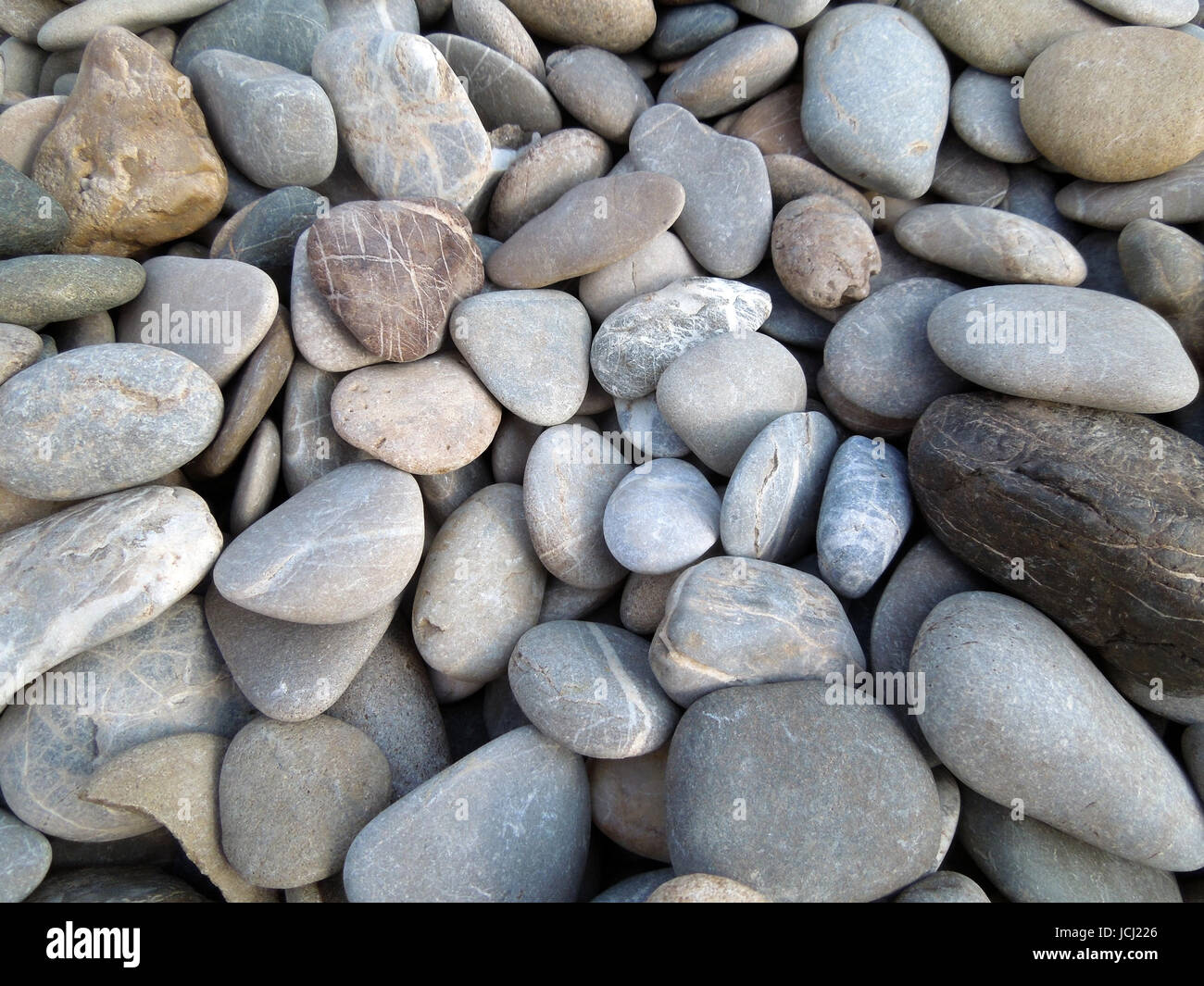 sunny illuminated full frame pebbles background Stock Photo - Alamy
