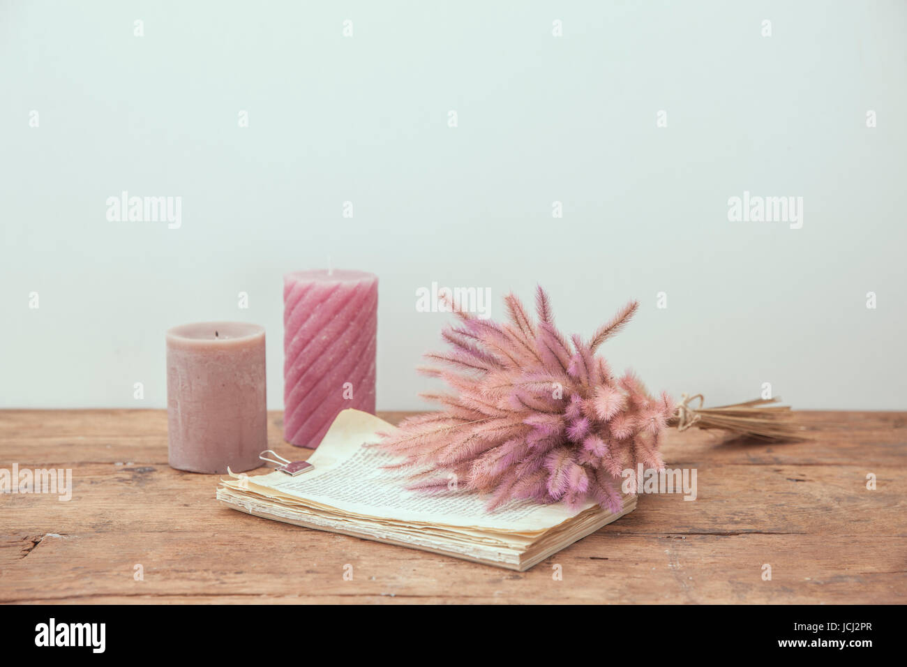 Candles, bunch of dry flowers and clipped book Stock Photo - Alamy