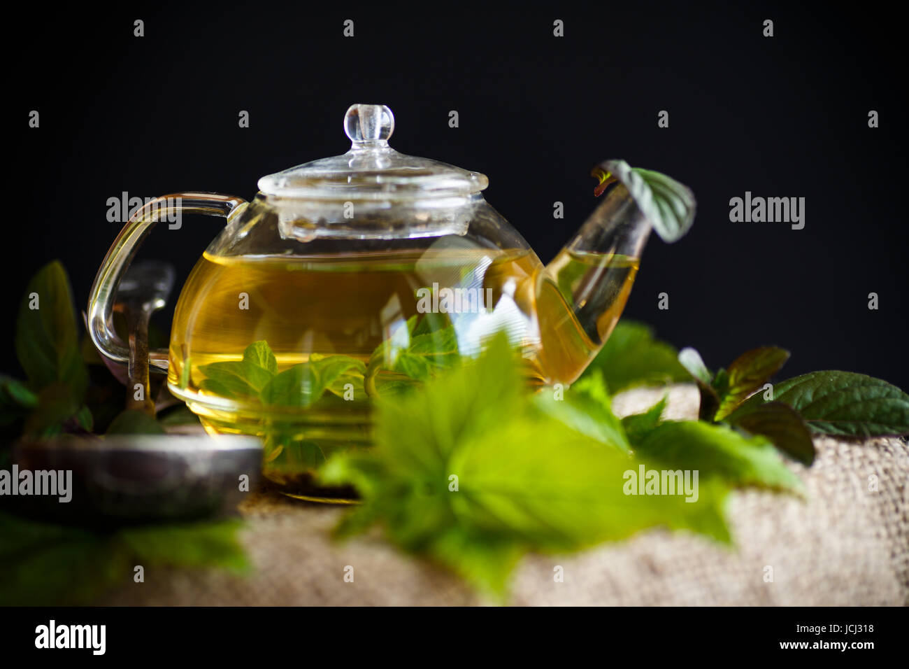 tea with currant leaves on a black background Stock Photo - Alamy