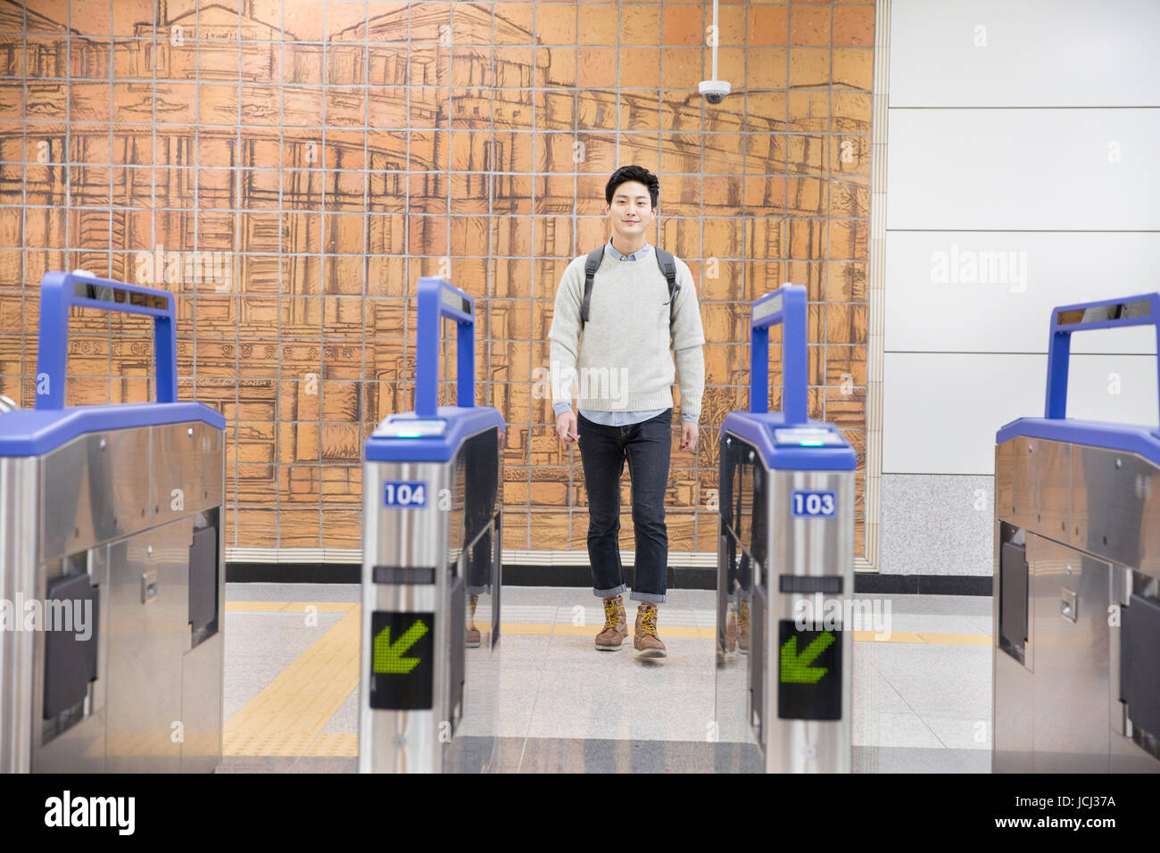Young smiling man walking towards turnstile at subway station Stock ...