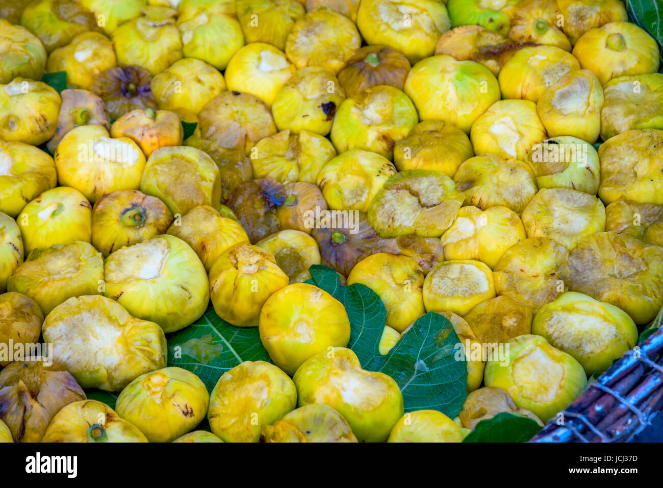 Ripe yellow figs in a basket with green leaf Stock Photo - Alamy