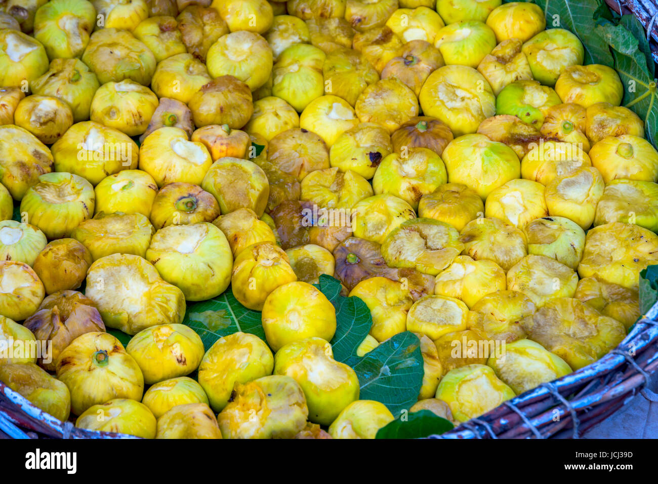 Ripe yellow figs in a basket with green leaf Stock Photo - Alamy
