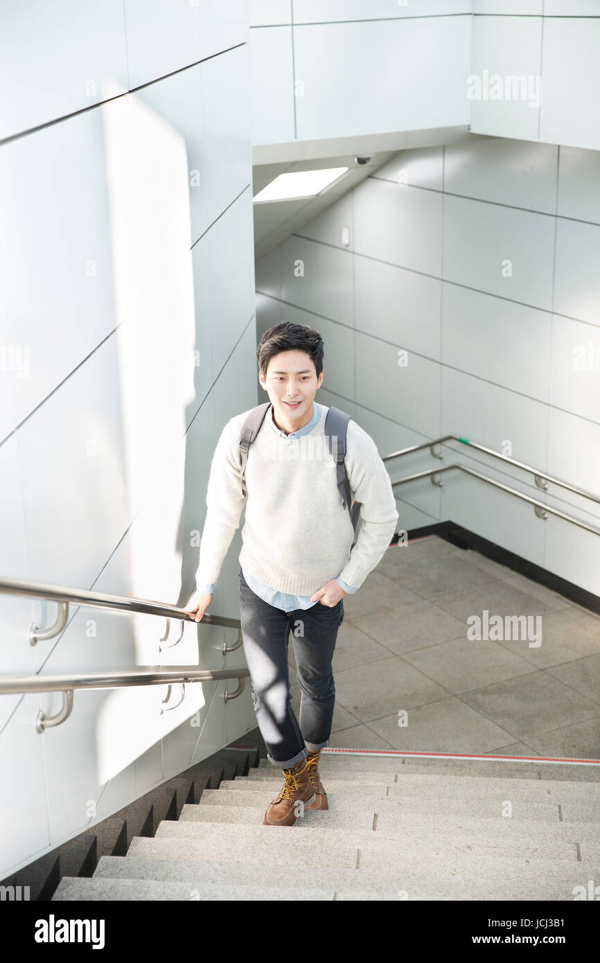 Young smiling man going upstairs at subway station Stock Photo - Alamy