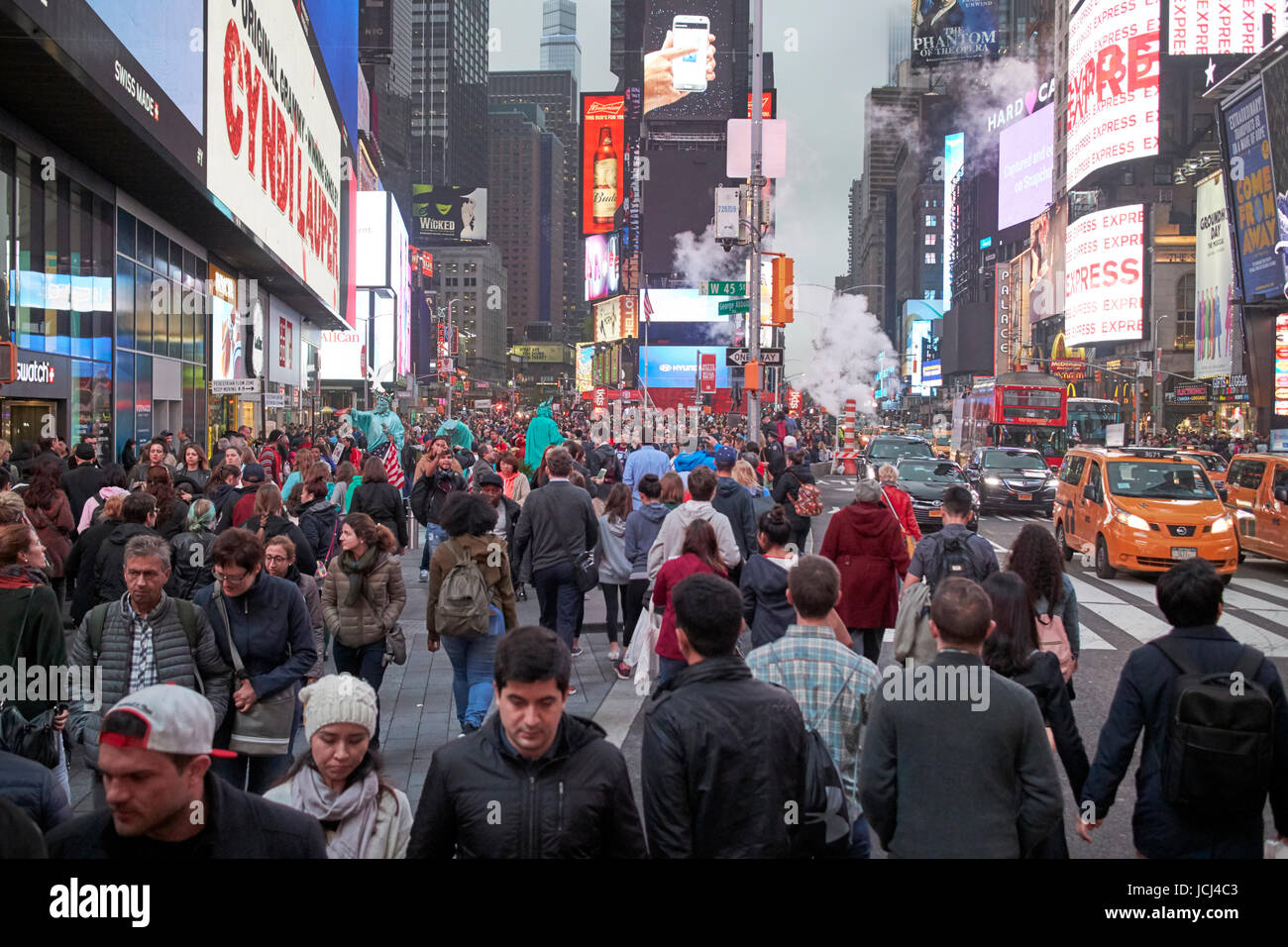 full busy sidewalk in the evening evening in Times Square New York City ...
