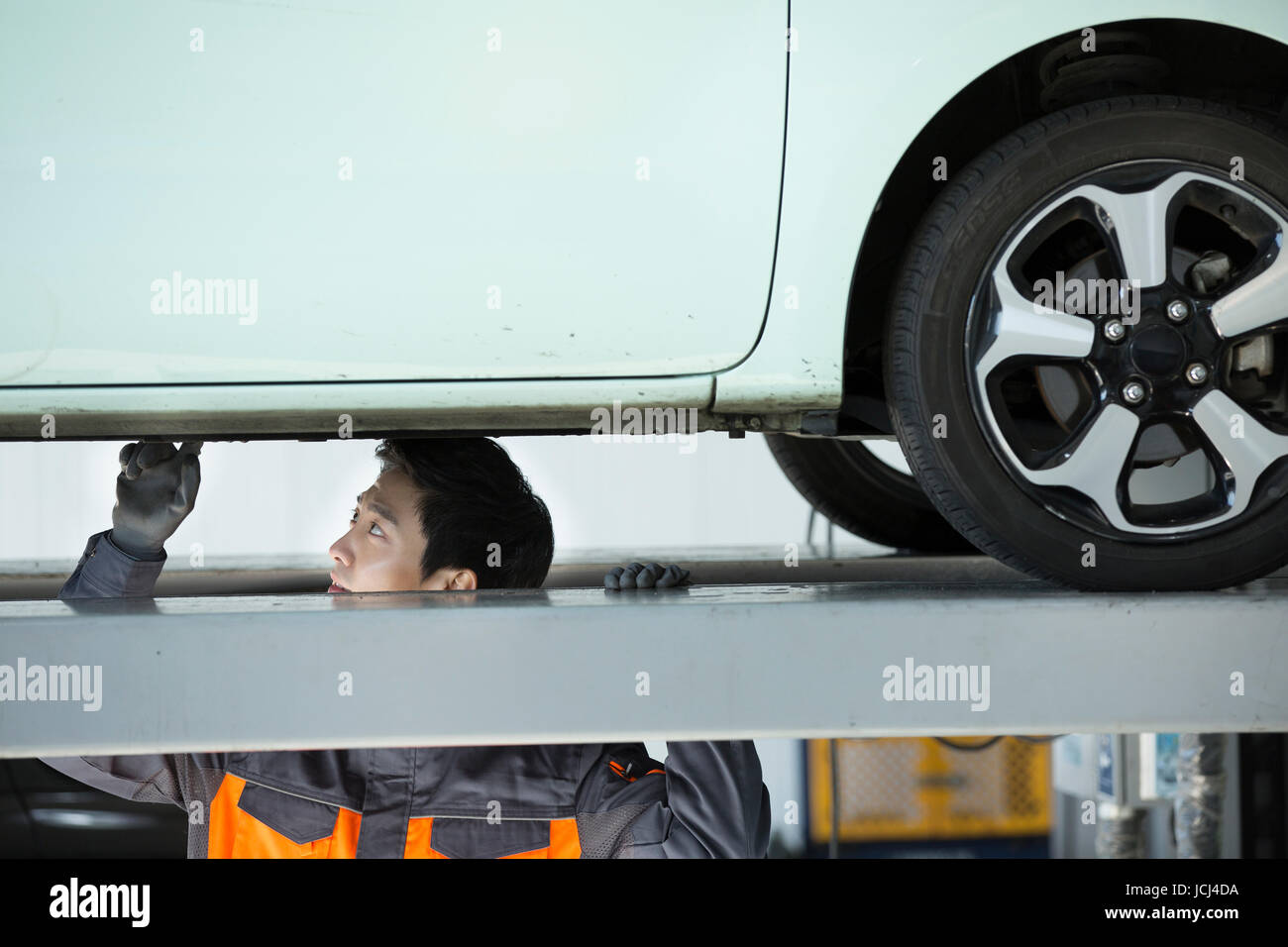Side view portrait of mechanic repairing a car Stock Photo - Alamy