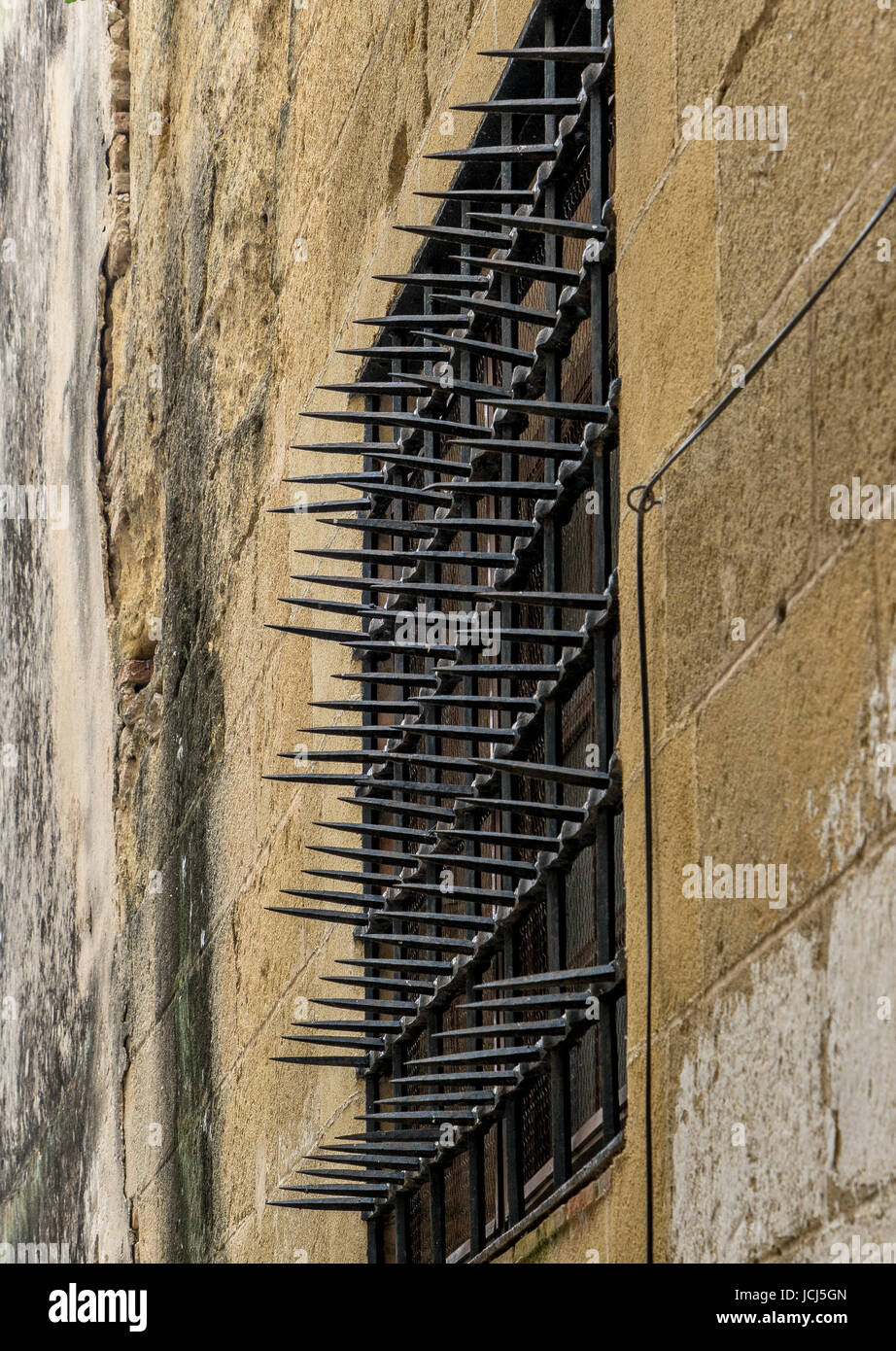 A spiked window grating on the side of an old church in Arcos de la ...