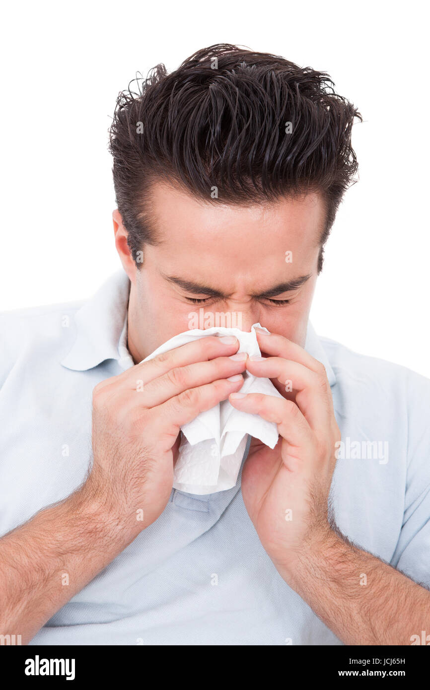 Young Man Blowing His Nose In A Tissue Over White Background Stock ...
