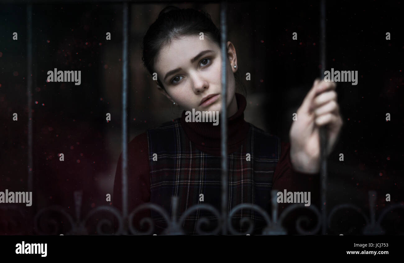 The girl with a sad look, left behind the iron gates of the castle ...