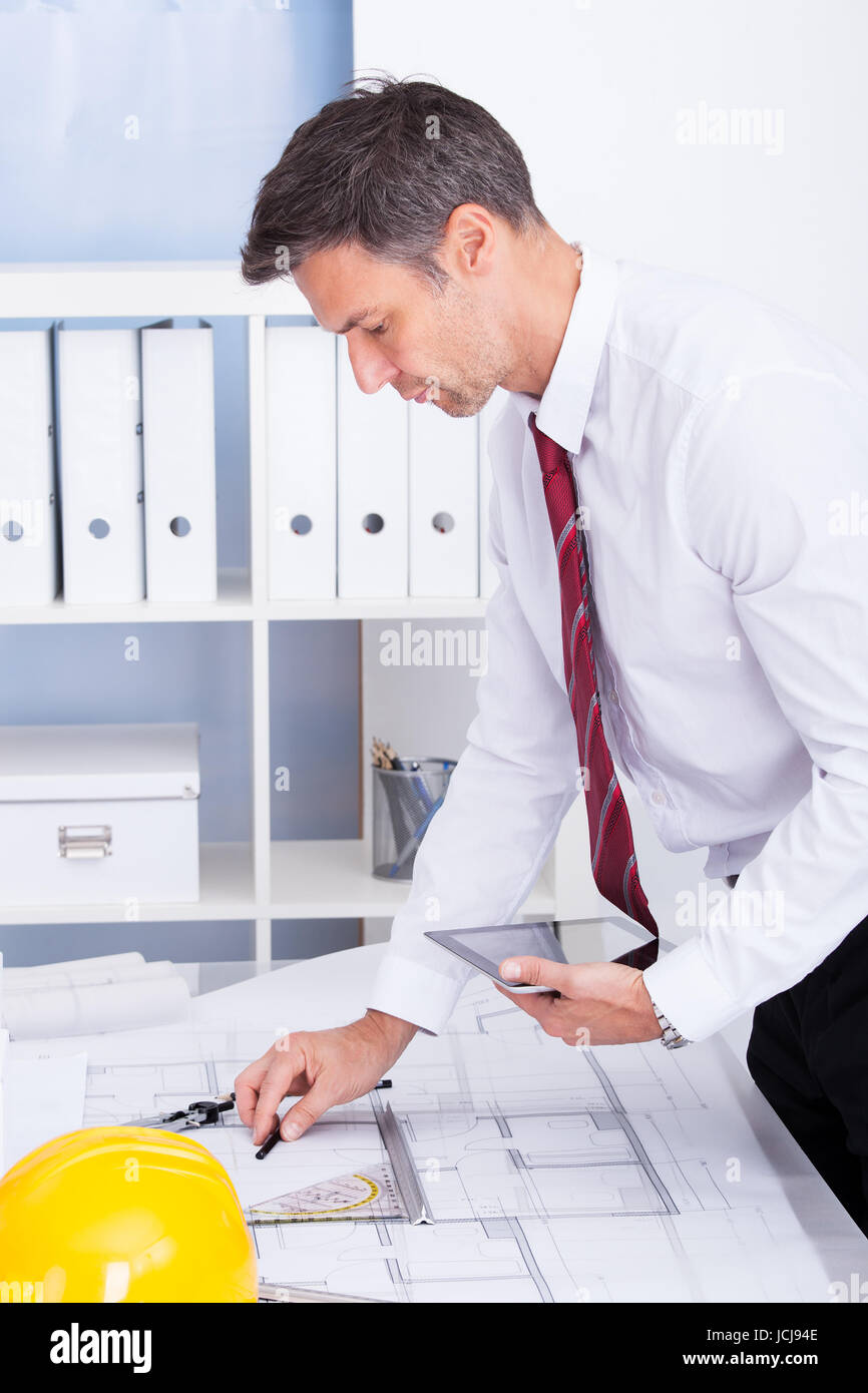 Portrait Of Male Architect Drawing Blueprint Using Digital Tablet Stock ...