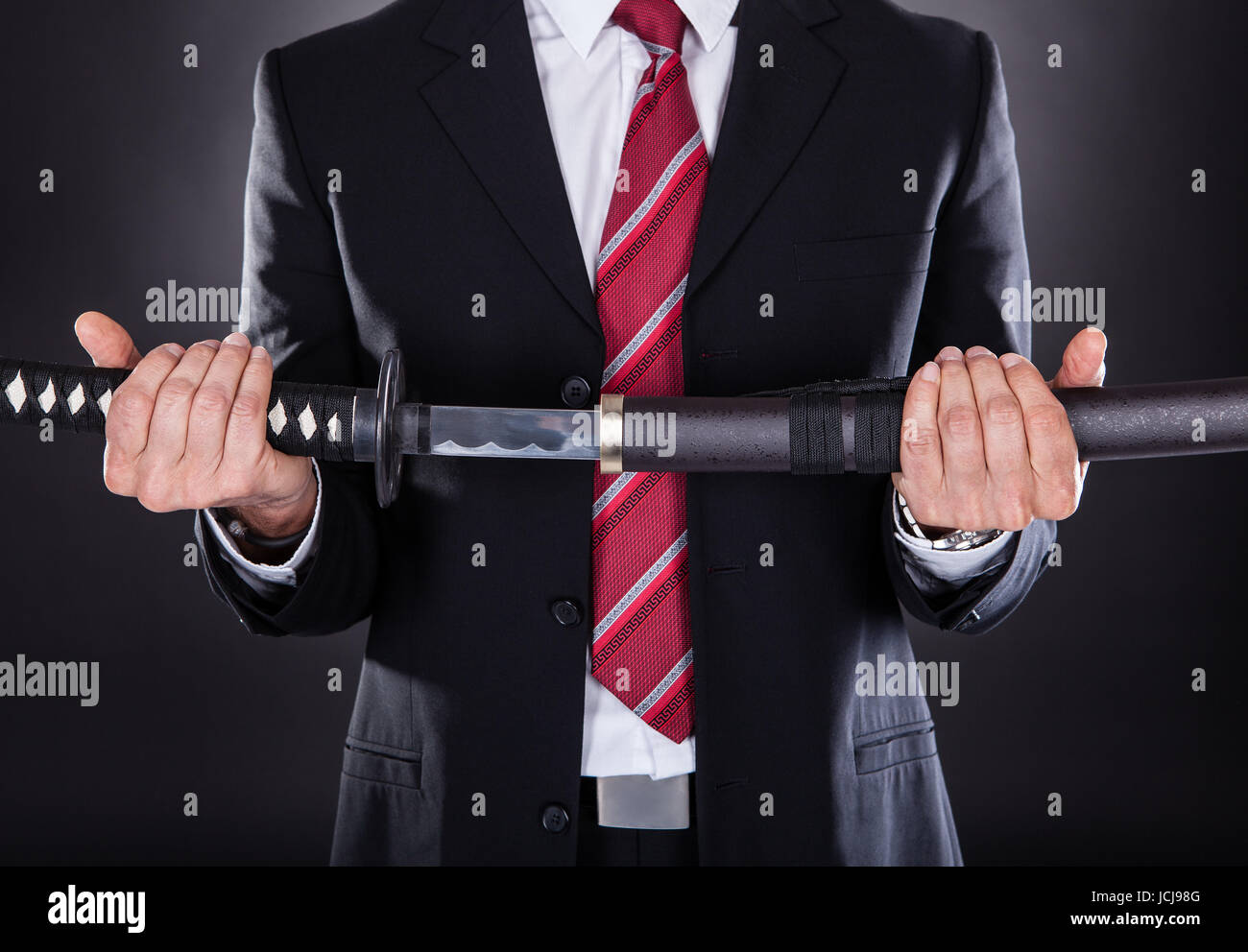 Close-up Of A Businessman Holding Sword Over Black Background Stock ...