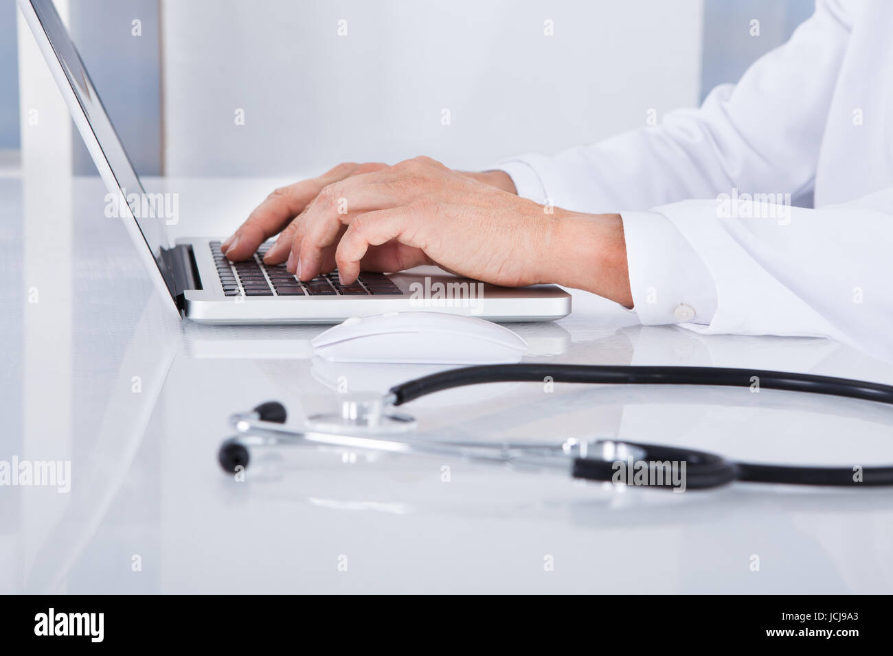 Close-up Of Doctor Using Laptop In Front Of Stethoscope At Desk Stock ...