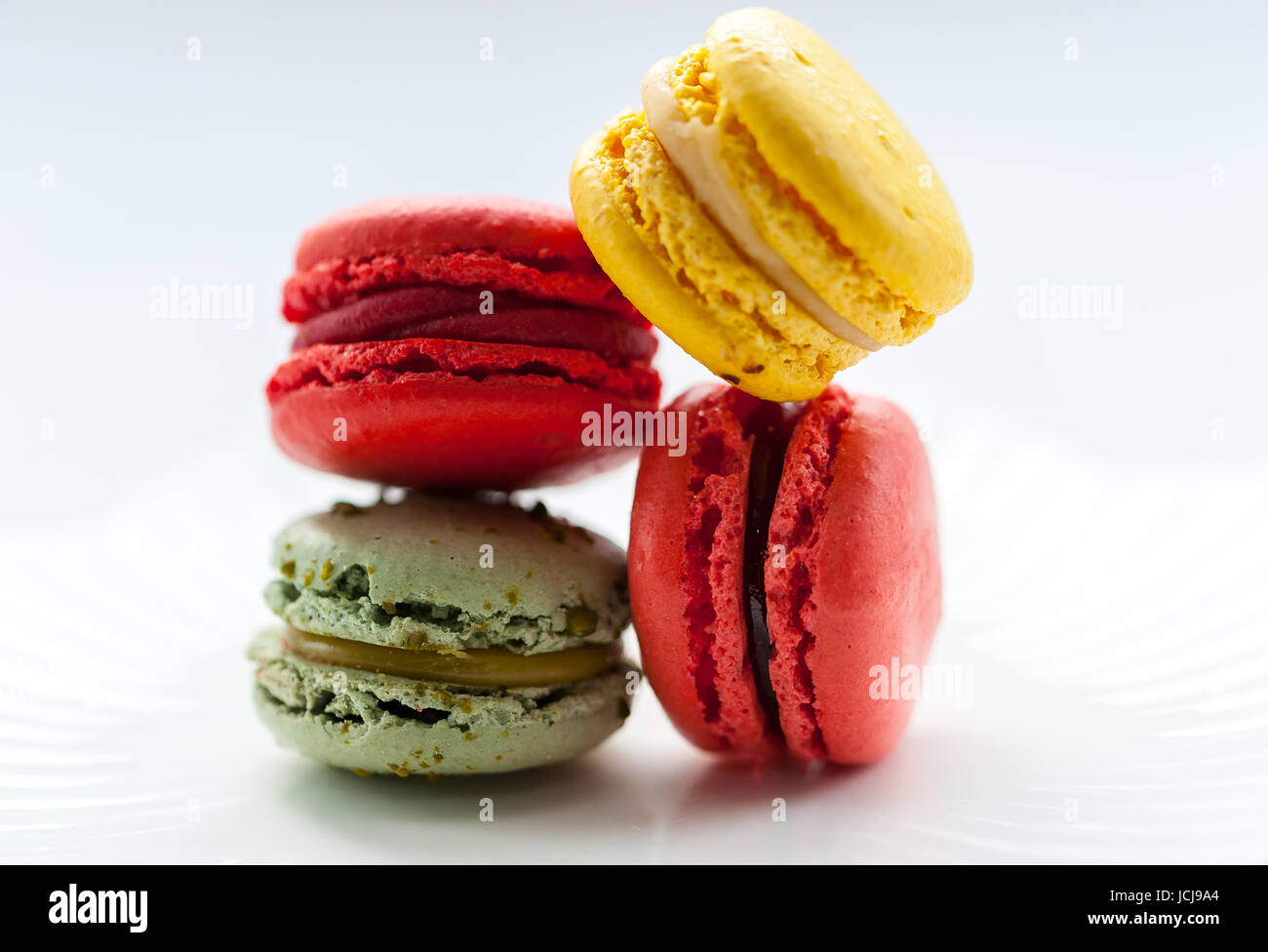 Colourful macarons on a vintage white plate Stock Photo - Alamy