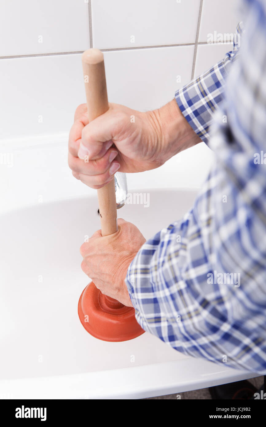 Portrait Of Male Plumber Using Plunger In Bathroom Sink Stock Photo - Alamy