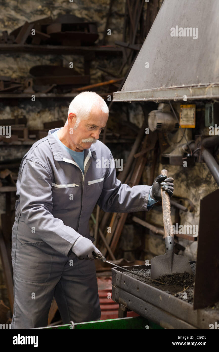 senior blacksmith forging the molten metal Stock Photo - Alamy