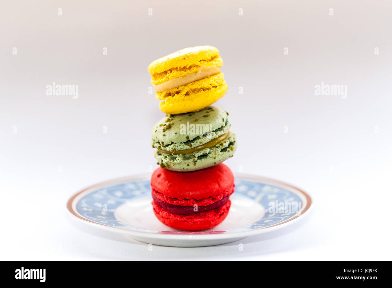 Colourful macarons on a vintage white plate Stock Photo - Alamy