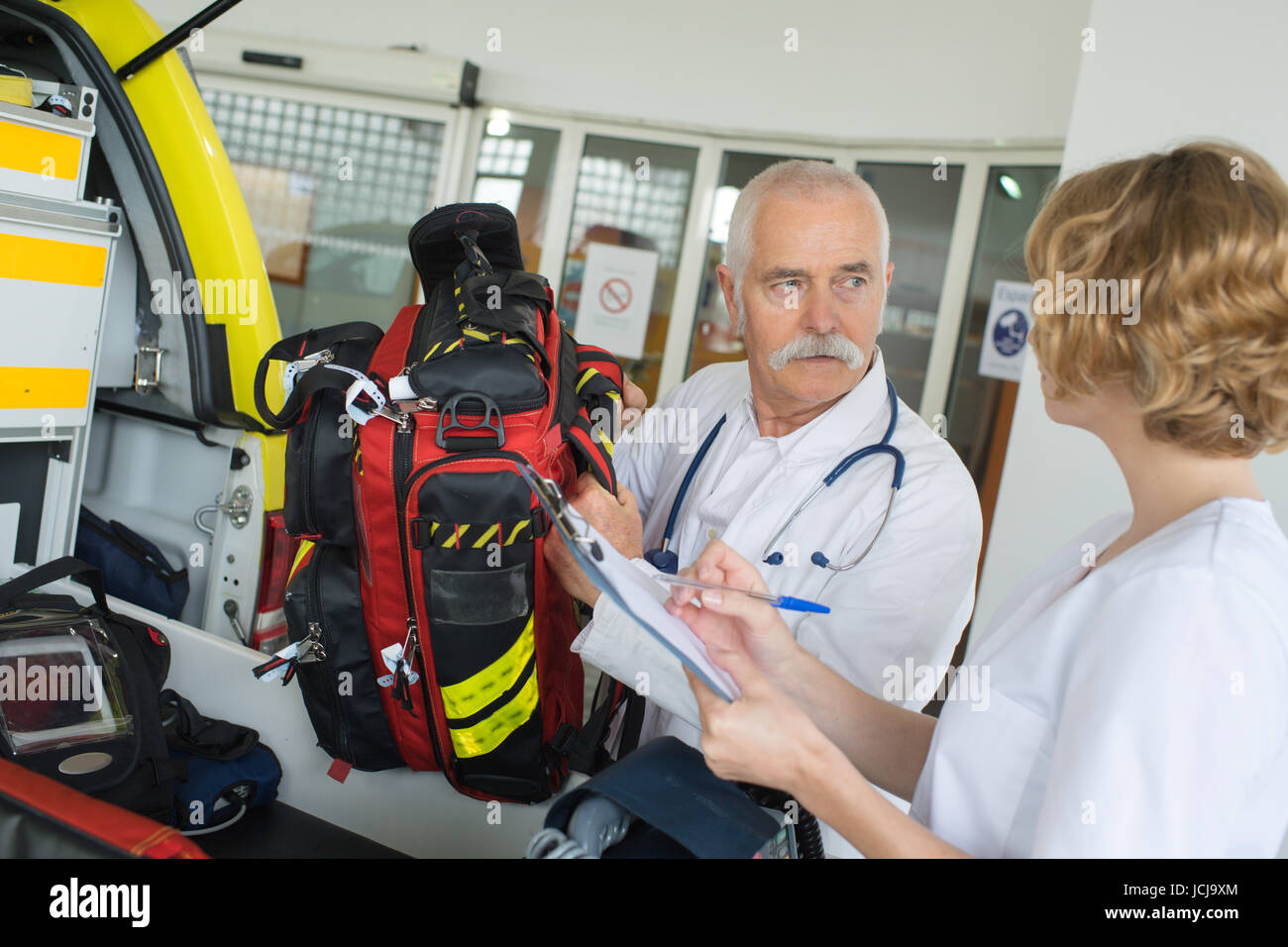 male and female ambulance crew checking their gear before intervention ...