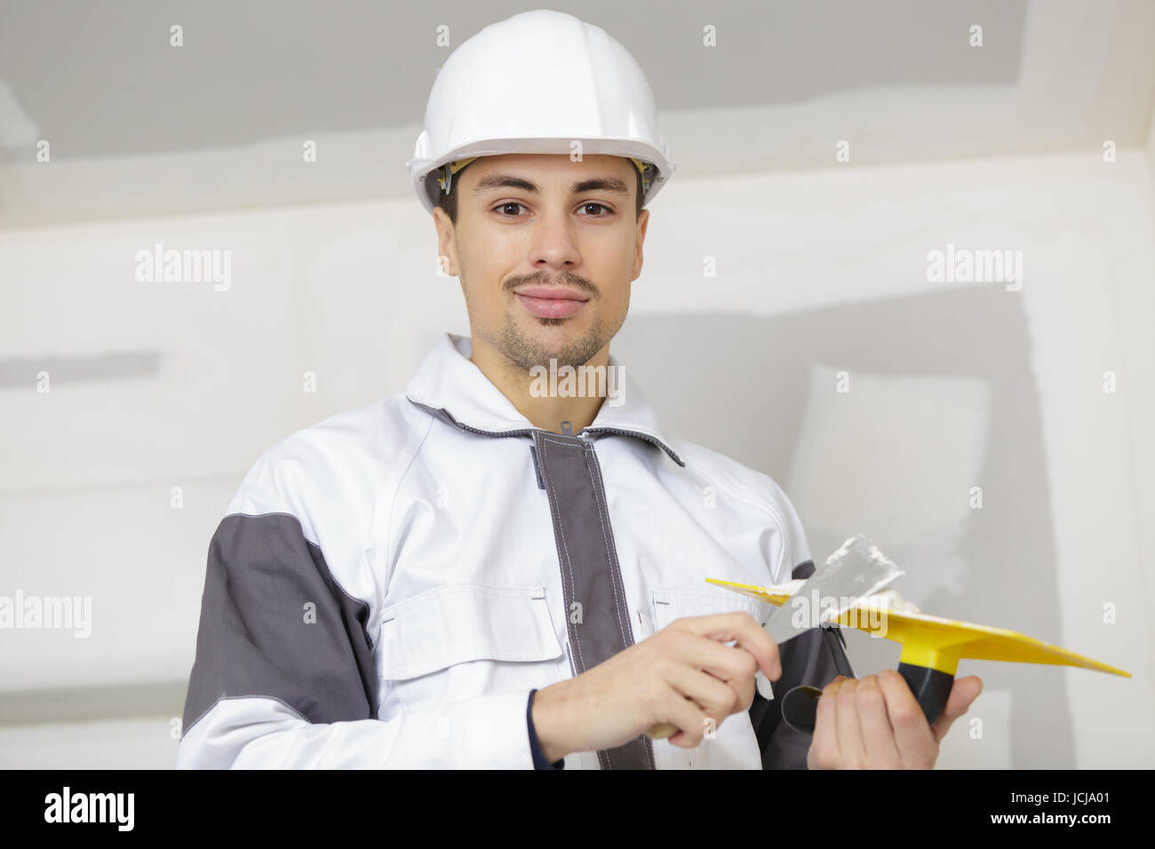 builder with spatula with plaster in hand Stock Photo - Alamy