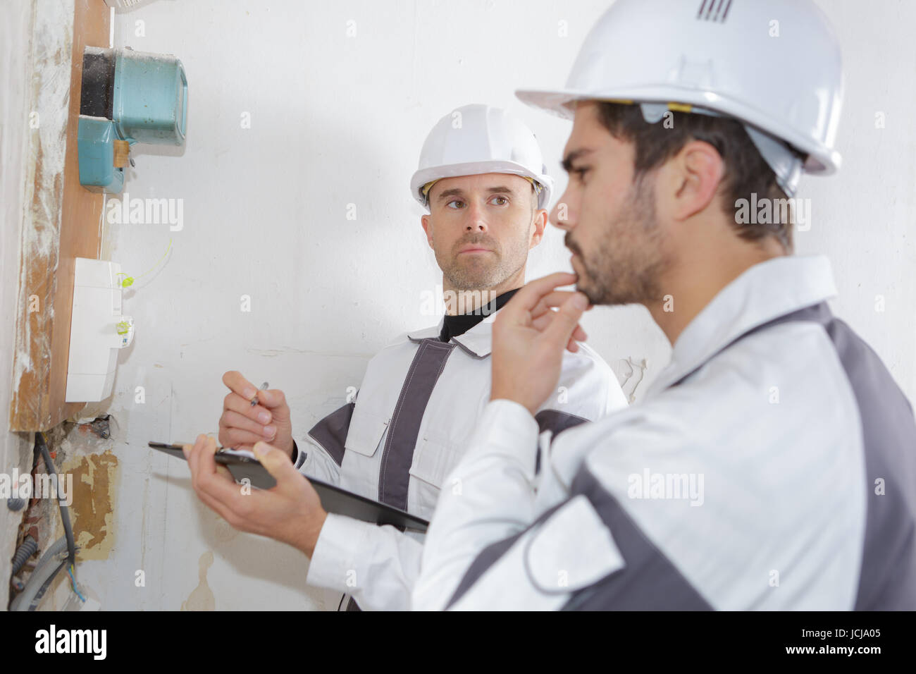 professional electrician installing components in electrical shield ...