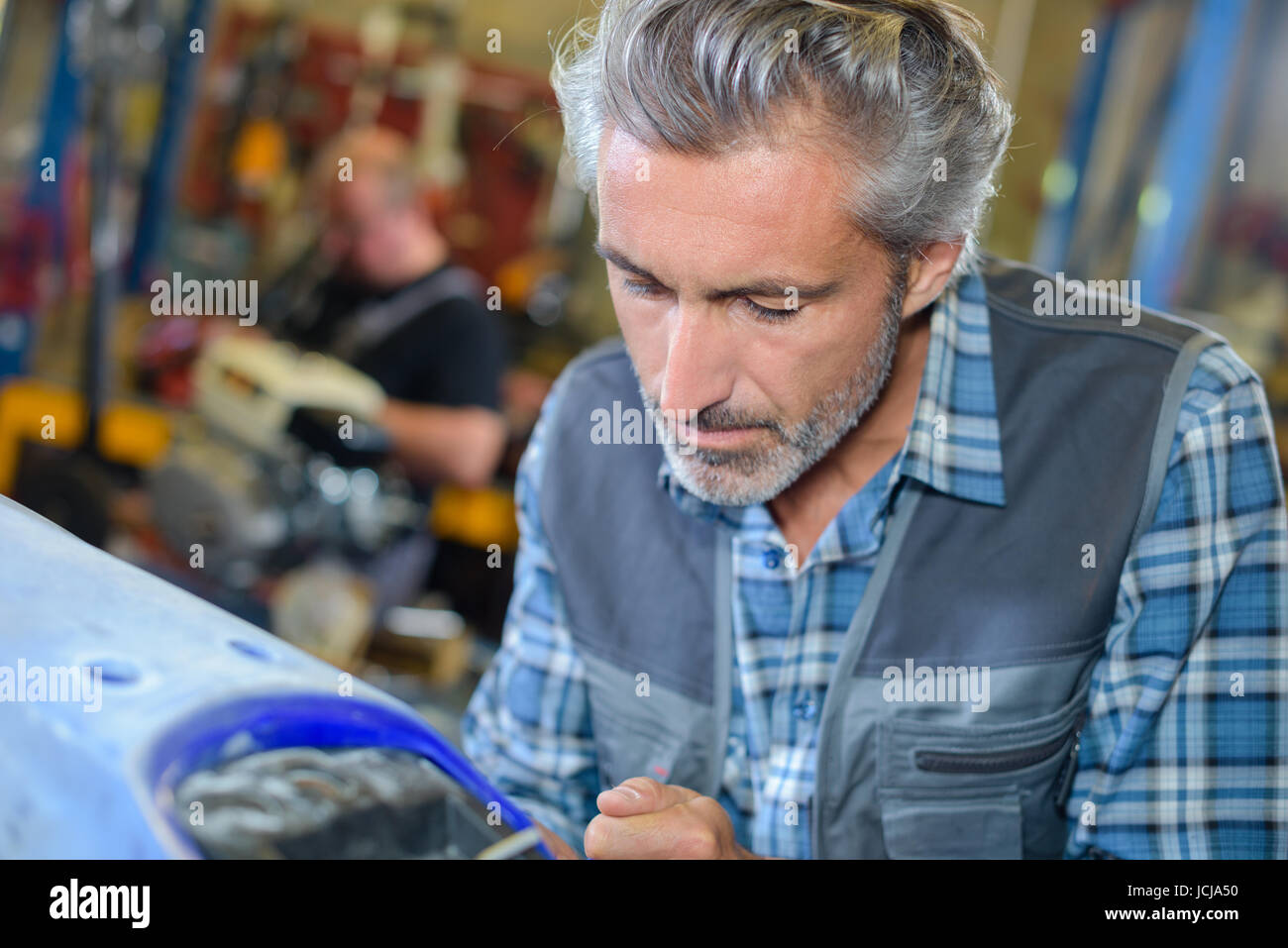 portrait of mature diligent mechanic man working with bike Stock Photo ...
