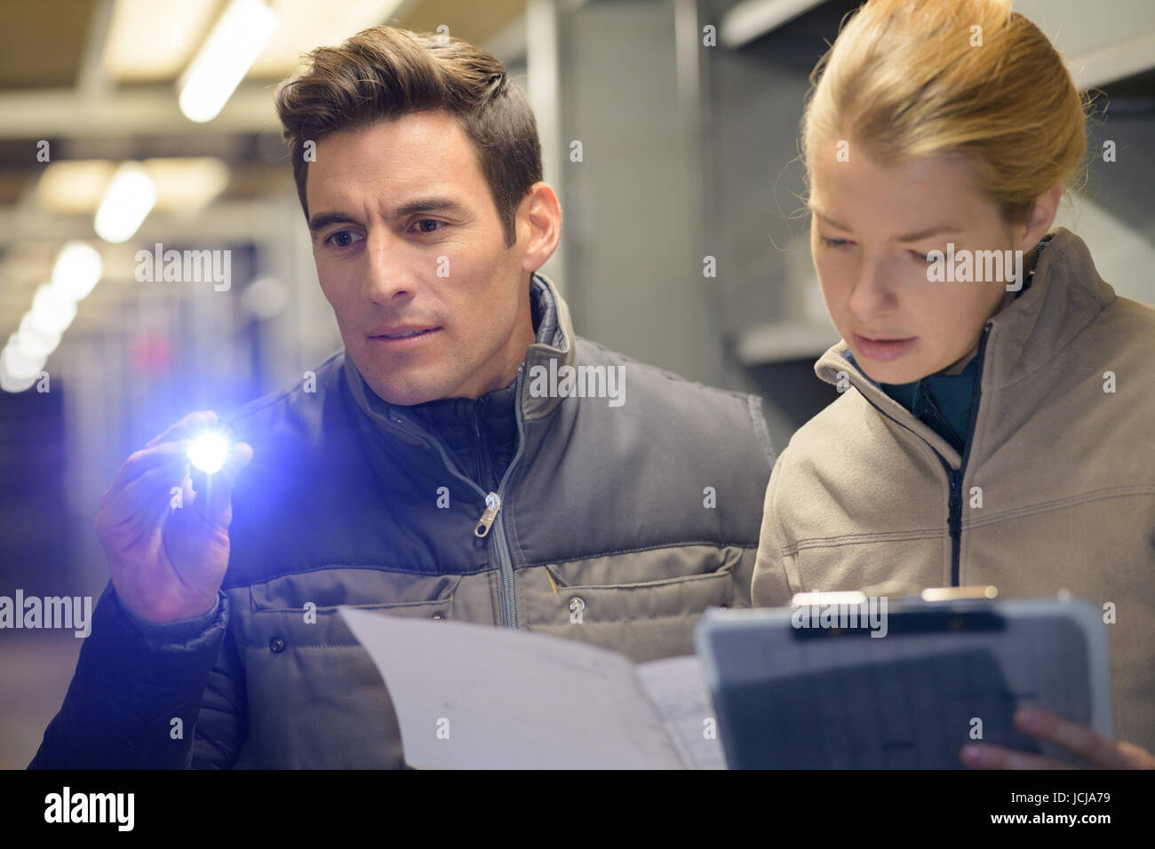 warehouse worker using a torch in a warehouse Stock Photo - Alamy