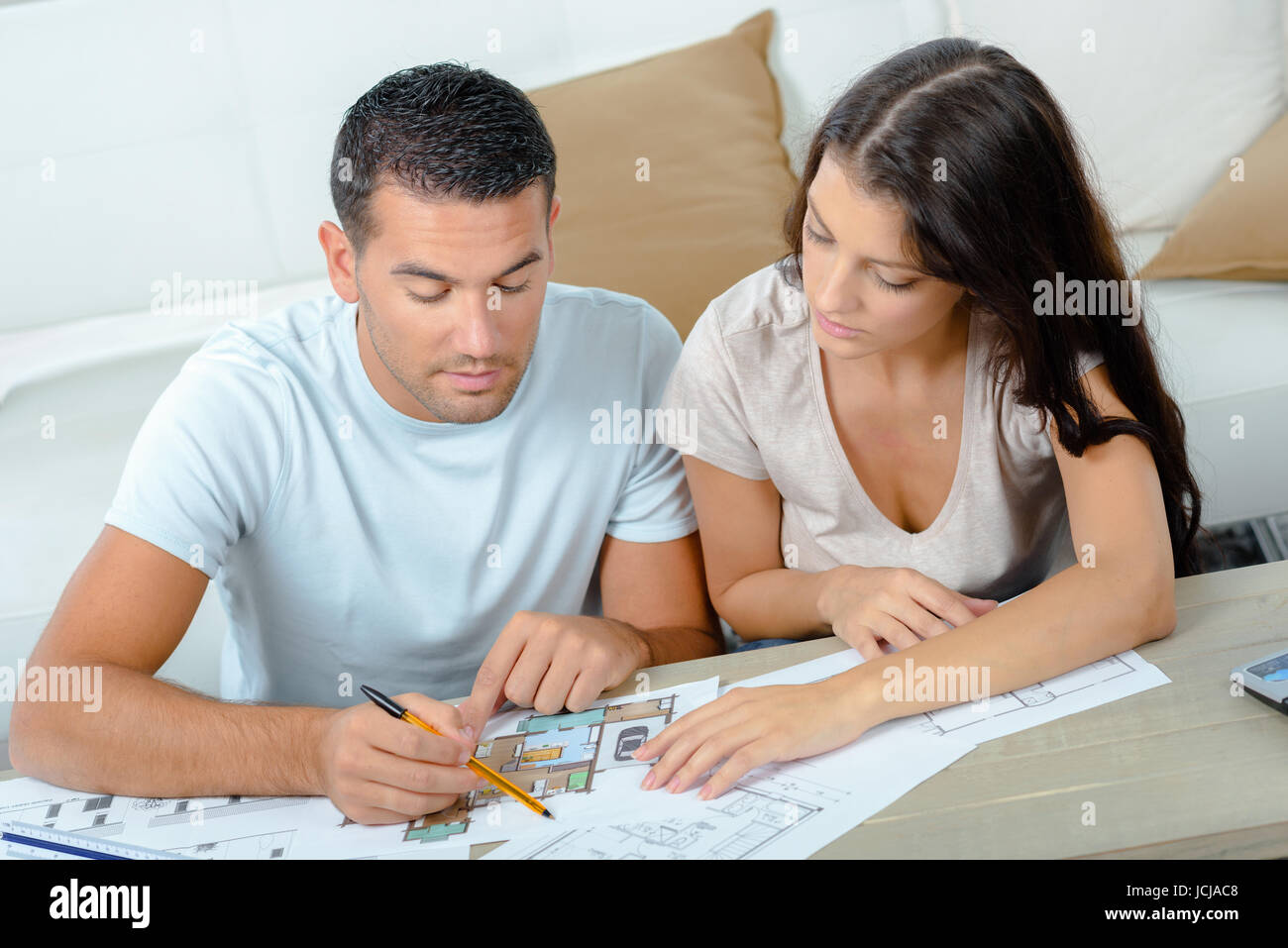 young couple planning project of their new home with blueprint Stock ...