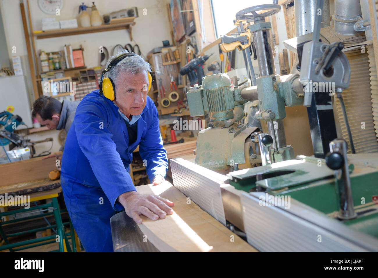 old carpenter sawing plank in his workshop Stock Photo - Alamy