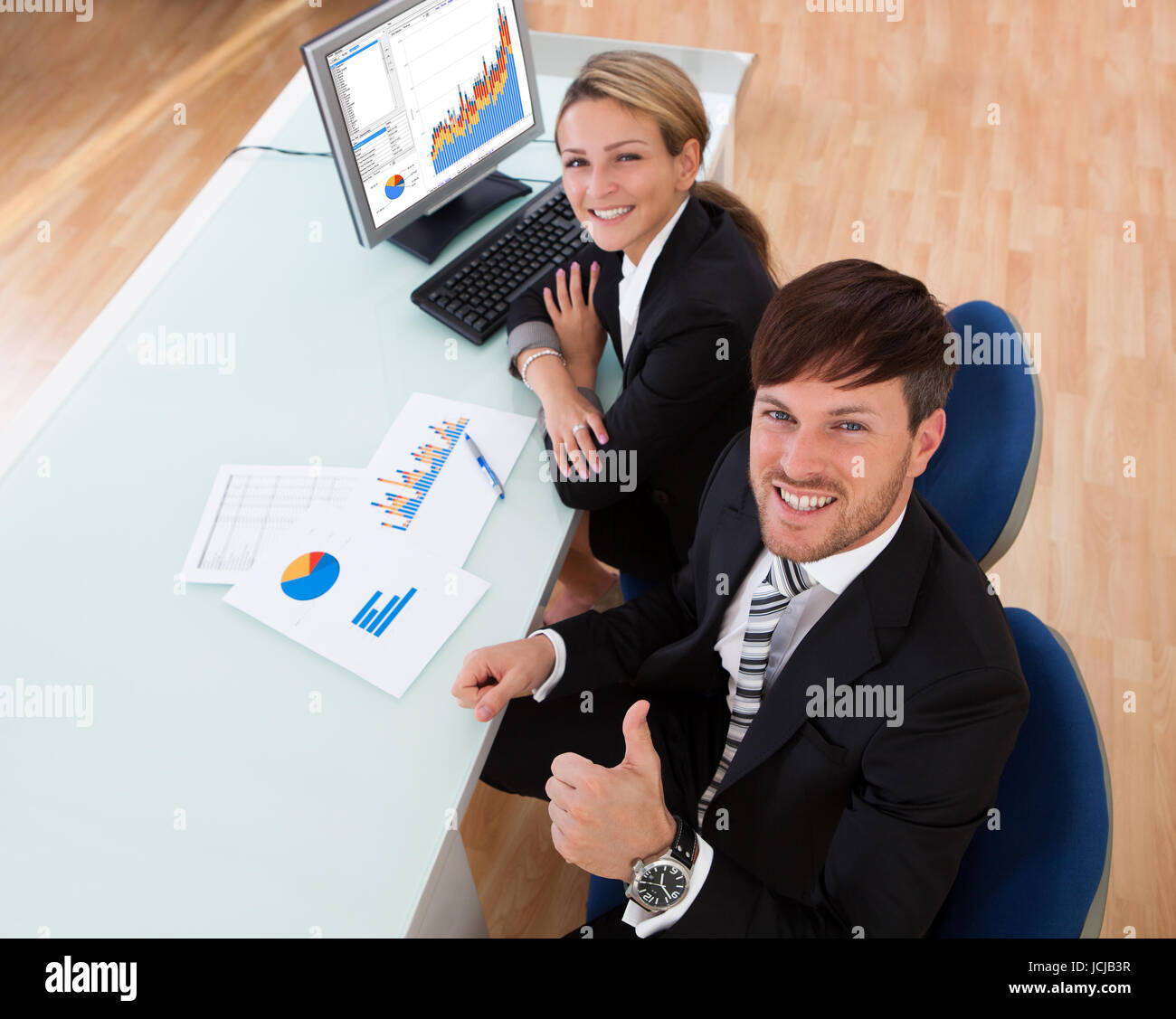 Over the shoulder view of two business partners discussing a colorful ...