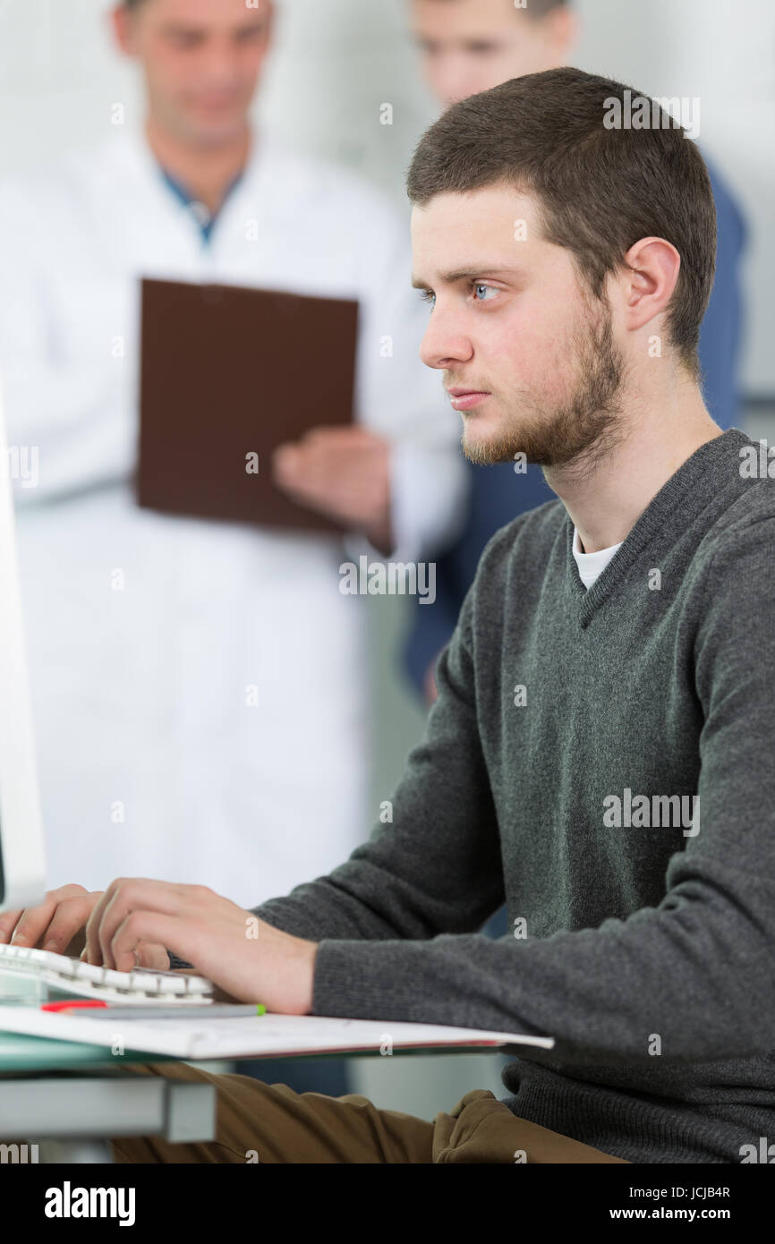 male student in classroom doing homework on computer in classroom Stock ...