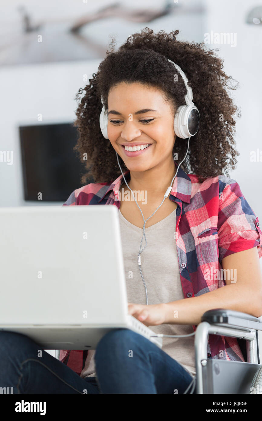 happy woman in wheelchair watching something on a laptop computer Stock ...