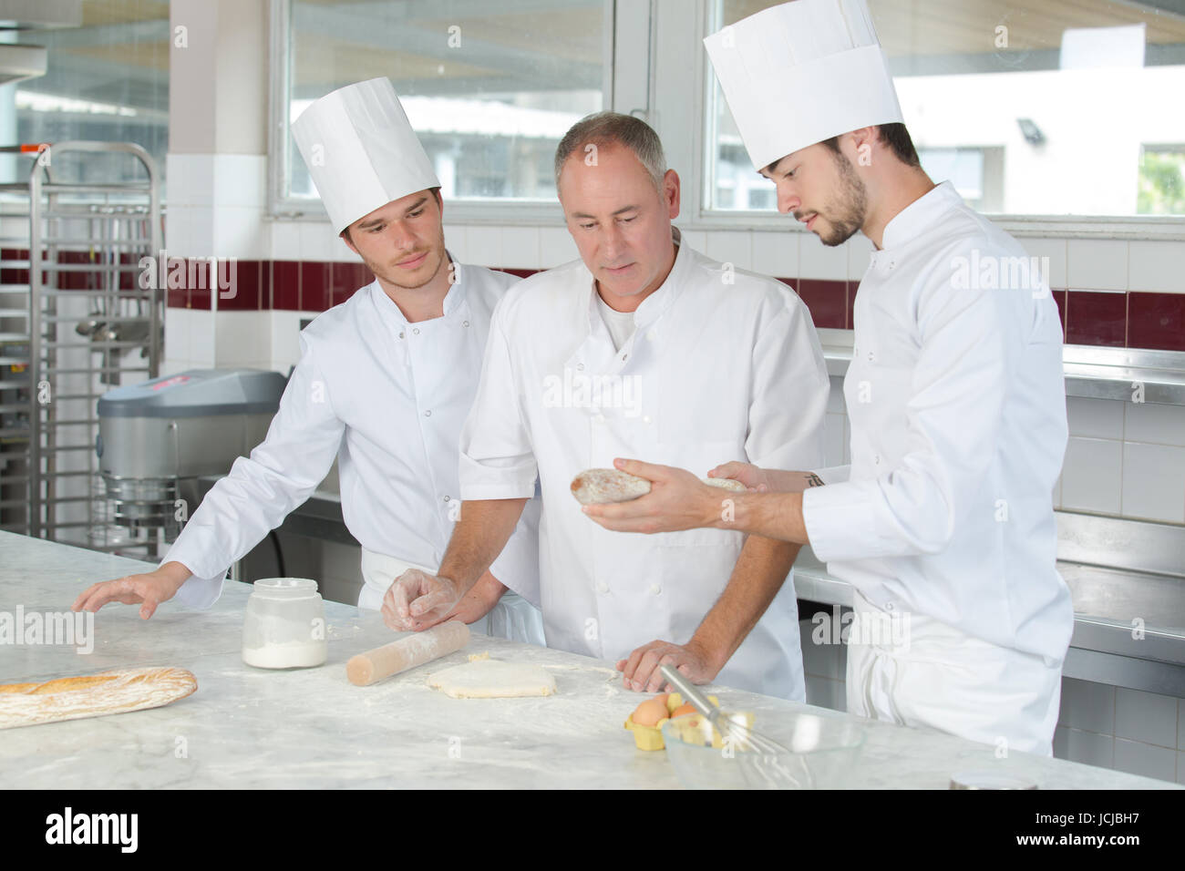 pastry chef watching students preparing delicious pastries Stock Photo ...