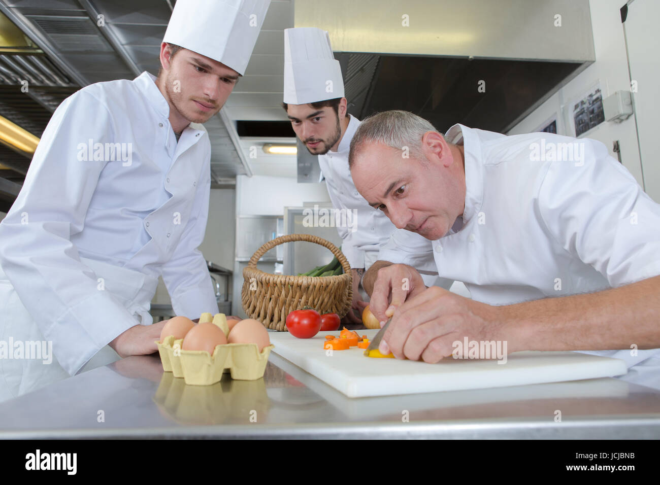 chef man cooking in the kitchen with assistants Stock Photo - Alamy