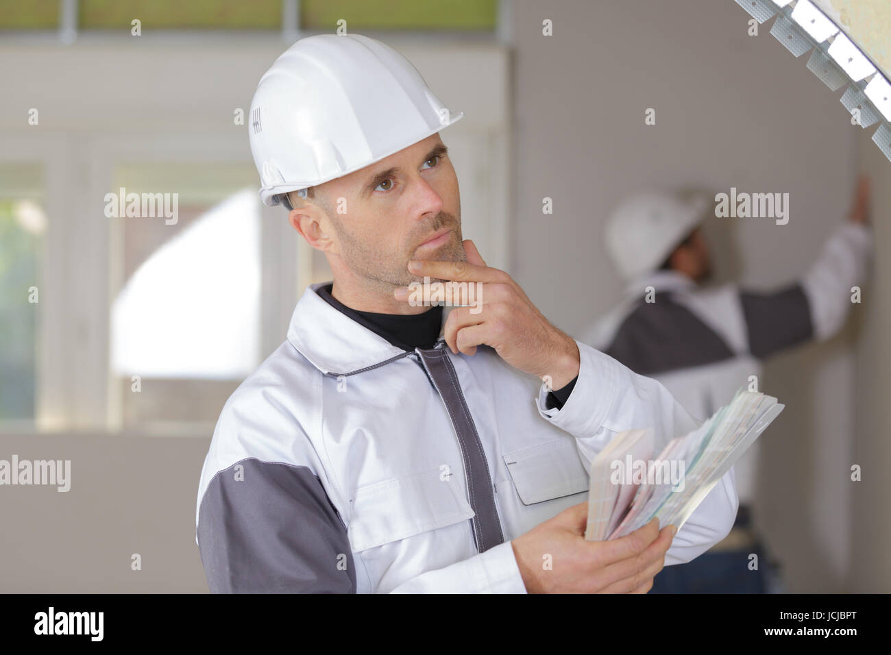 confused construction worker holding spirit level in a new house Stock ...