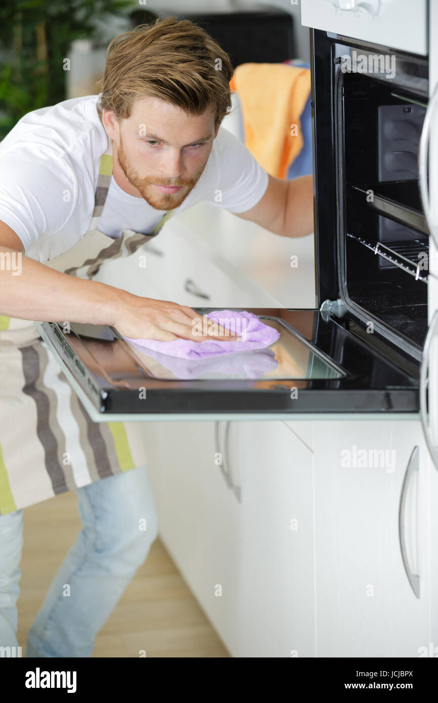 man cleaning oven at home Stock Photo - Alamy