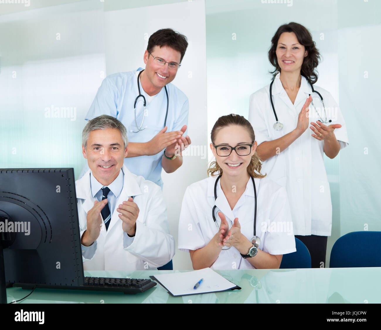 Happy medical team compridsing male and female doctors smiling broadly ...