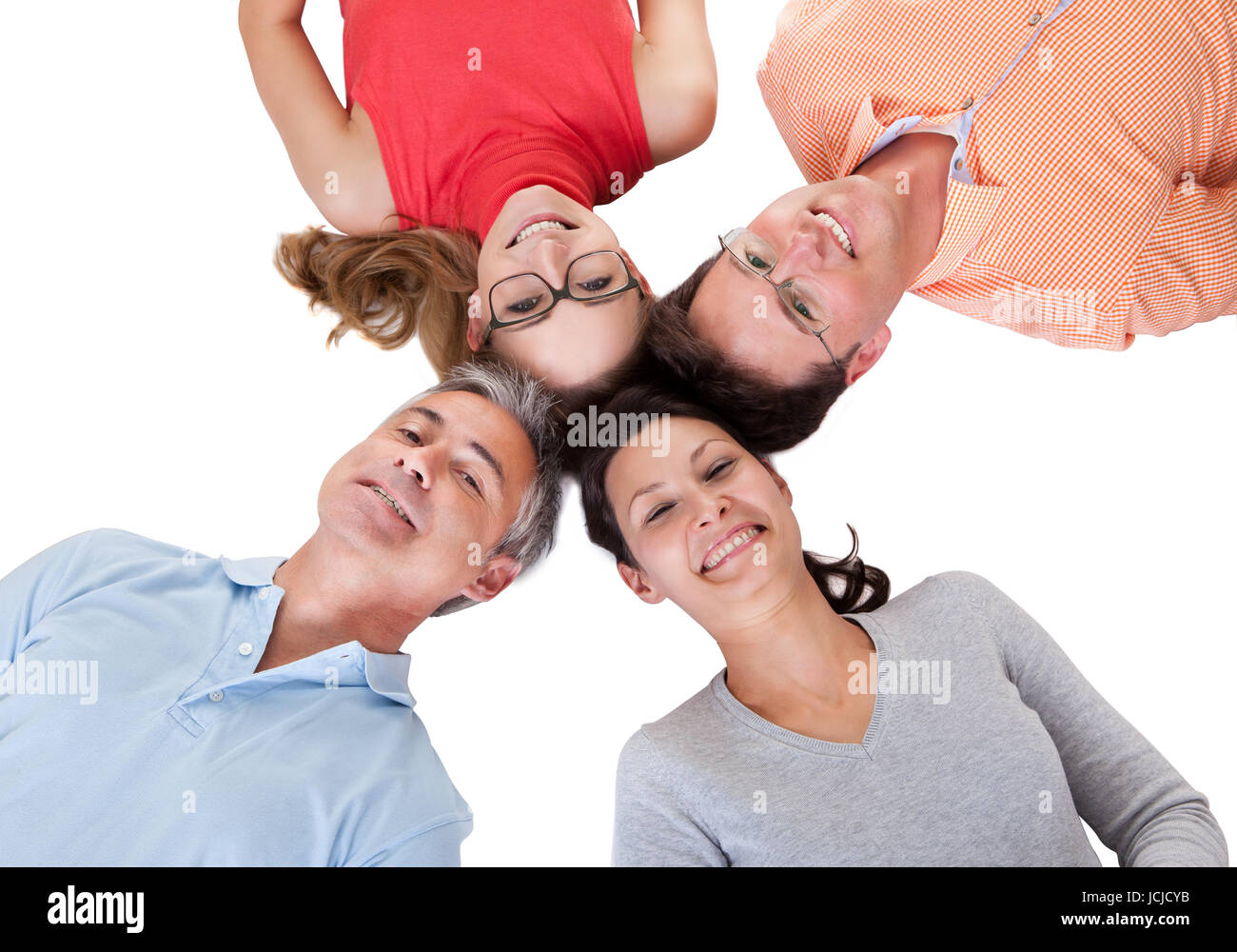 Conceptual image of four smiling middle-aged friends facing inwards ...