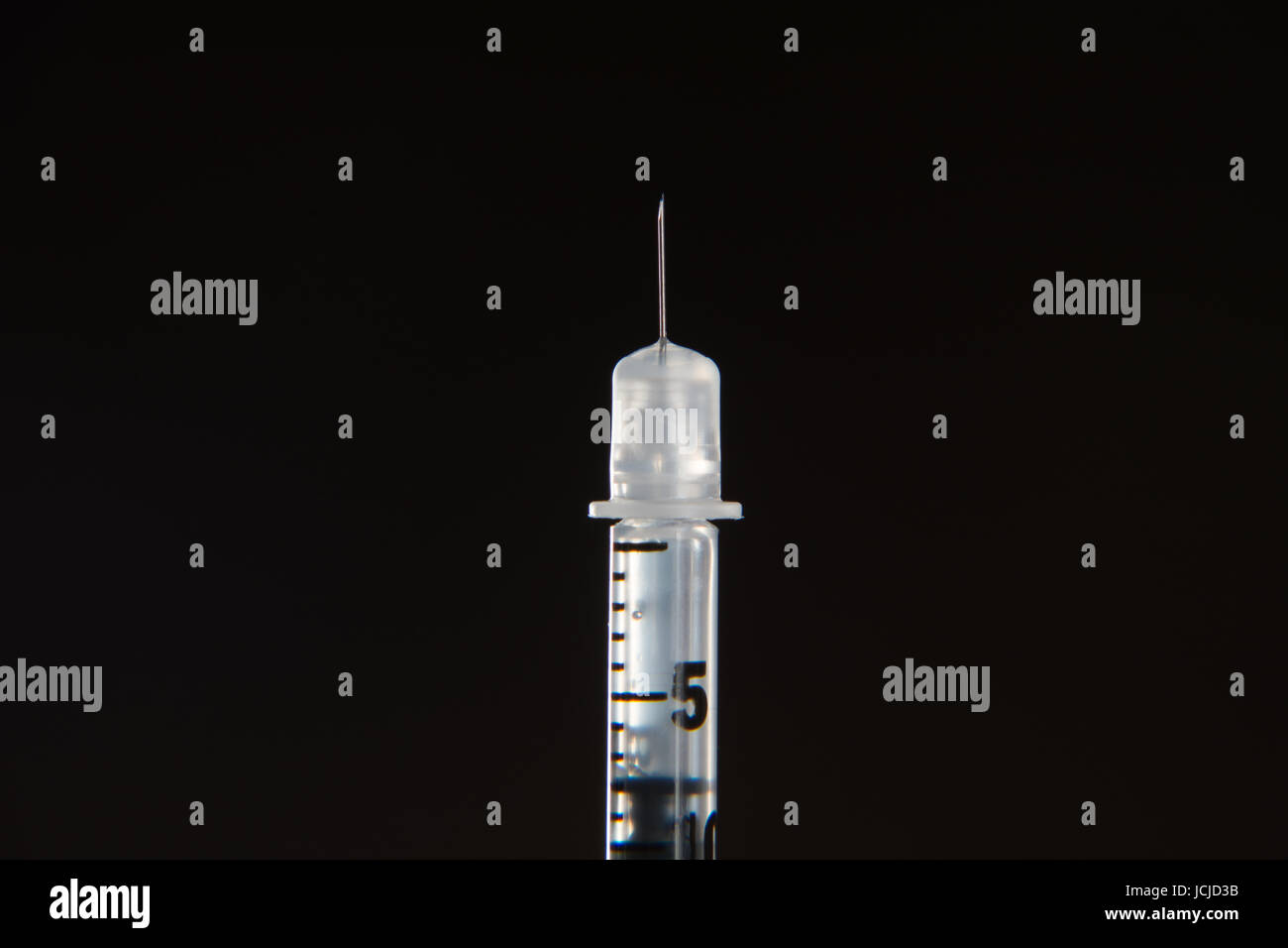 A single syringe with a black background Stock Photo - Alamy