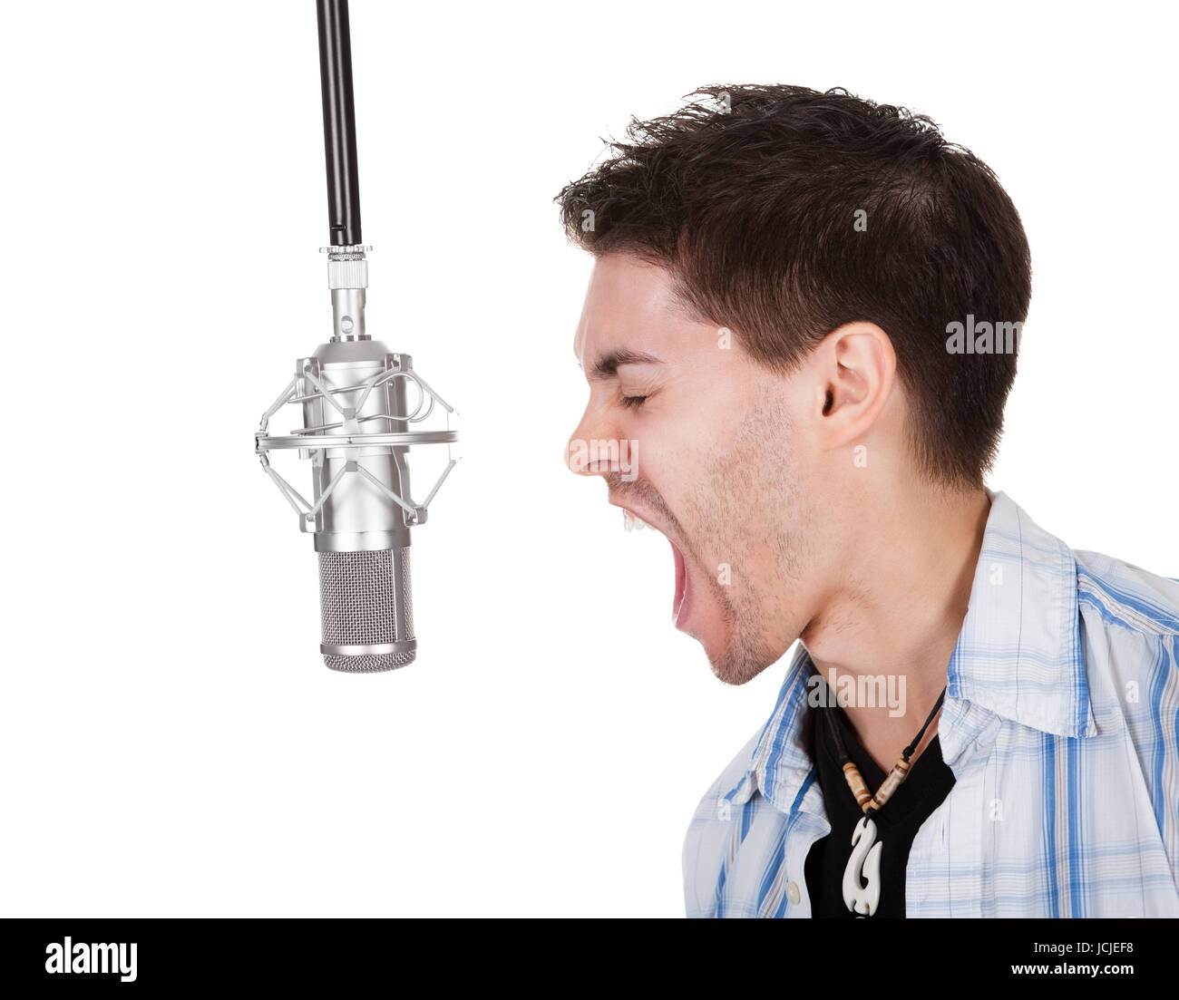 Portrait of a young singer screaming into microphone Stock Photo - Alamy