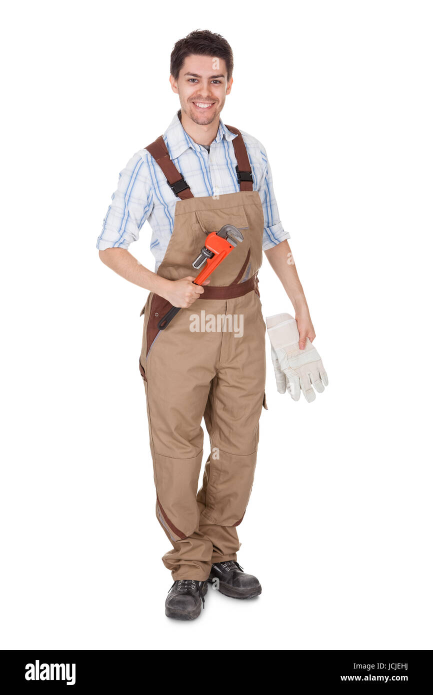Smiling handsome handyman in work clothes with tool Stock Photo - Alamy
