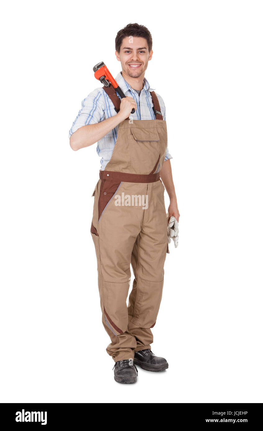 Smiling handsome handyman in work clothes with tool Stock Photo - Alamy
