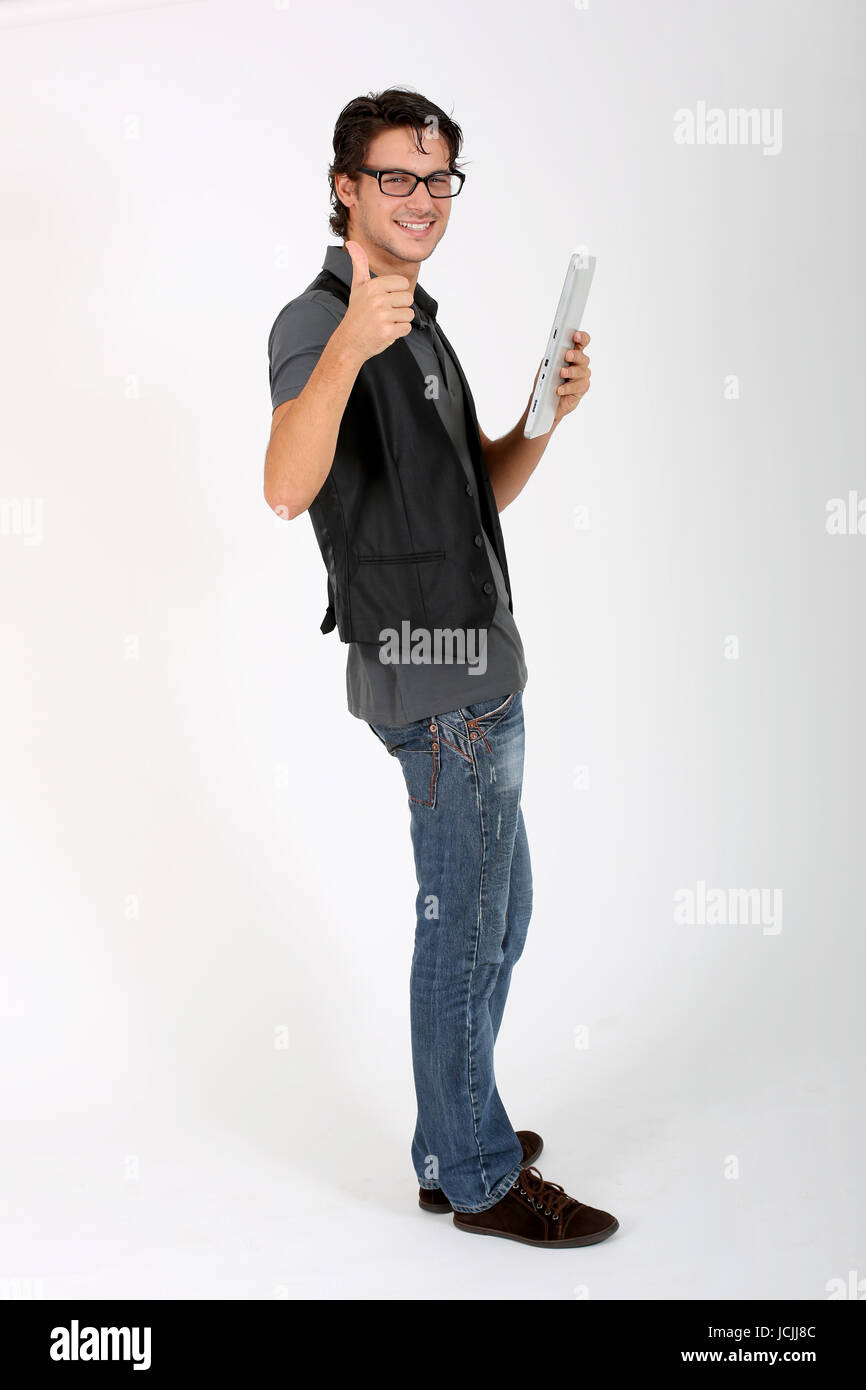 Cheerful guy with tablet showing thumb up Stock Photo - Alamy